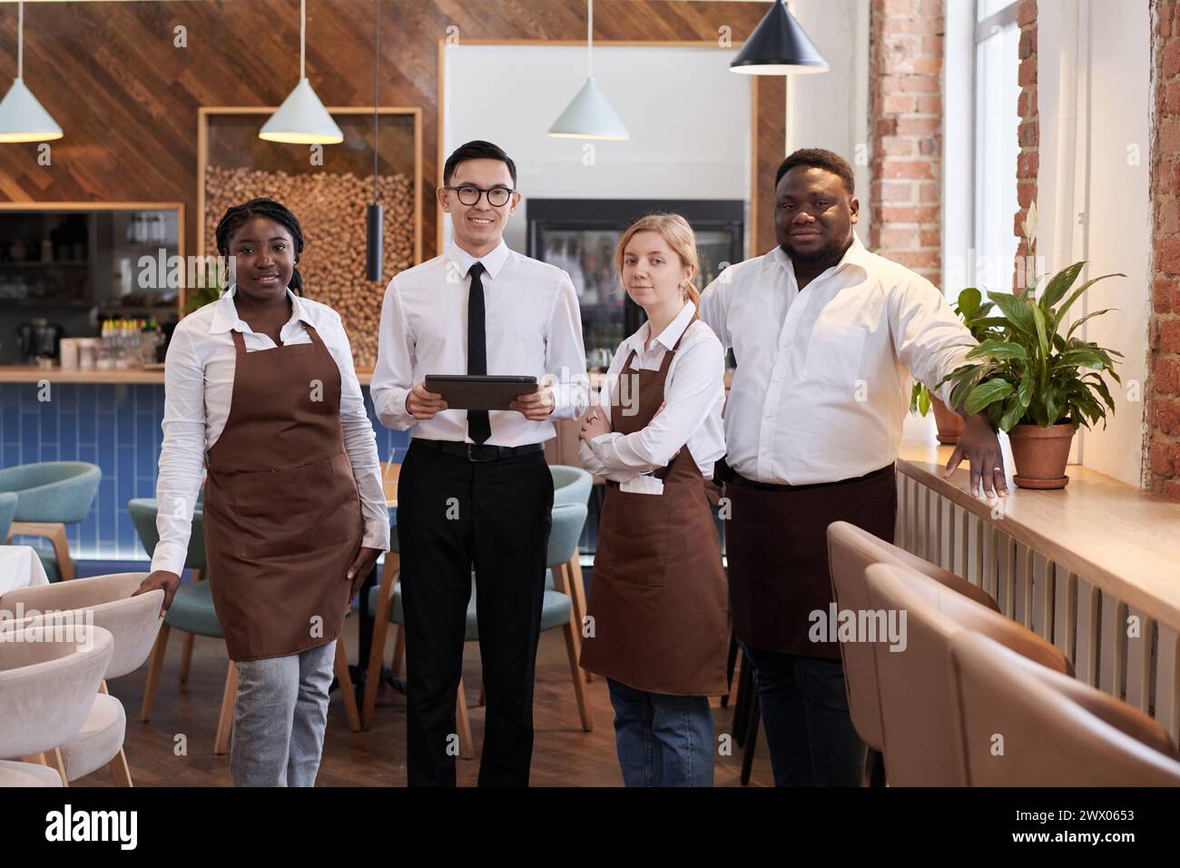 Medium long group portrait of young multi-ethnic waiting staff posing ...