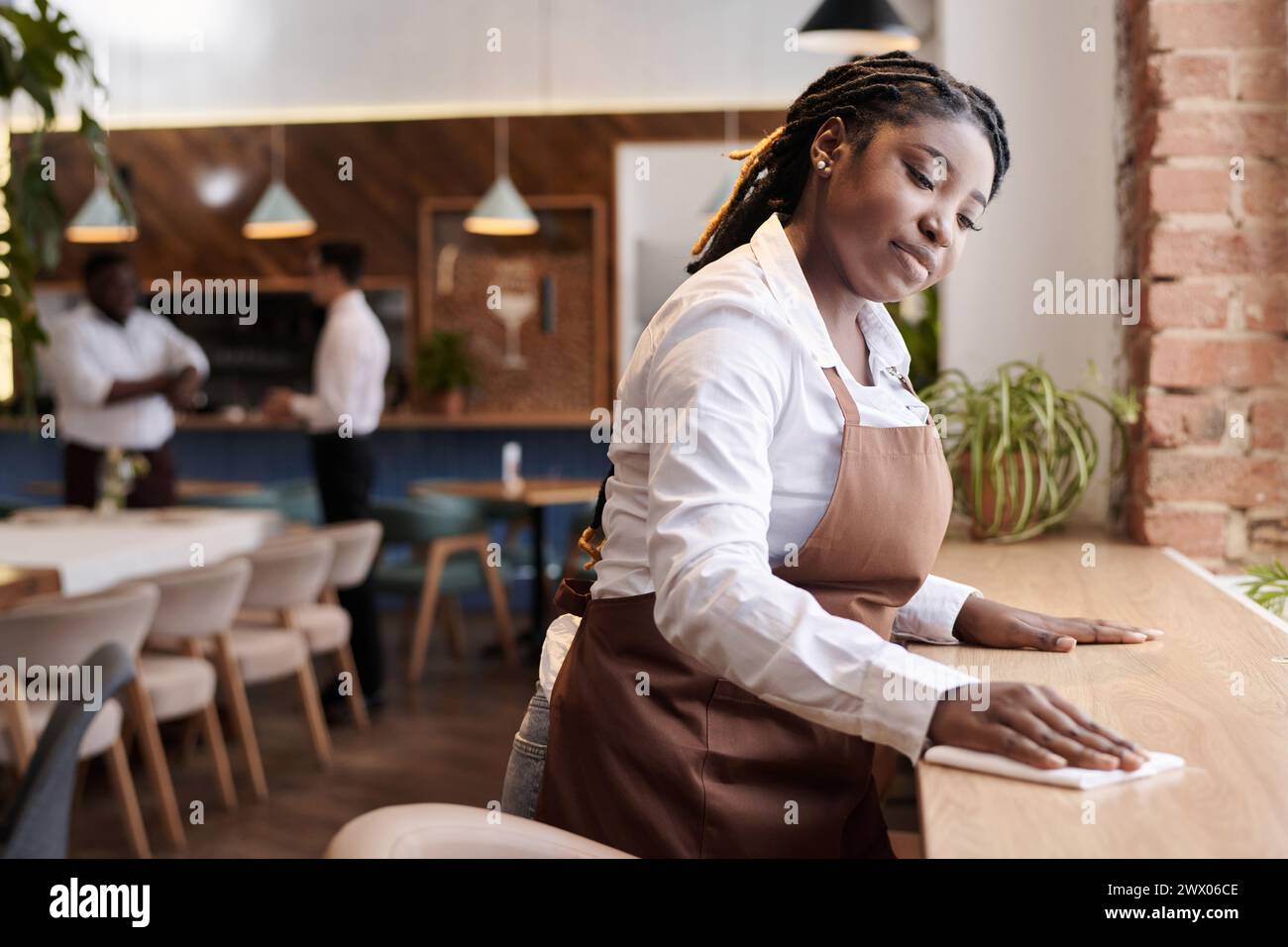 Young waitress wiping table hi-res stock photography and images - Alamy