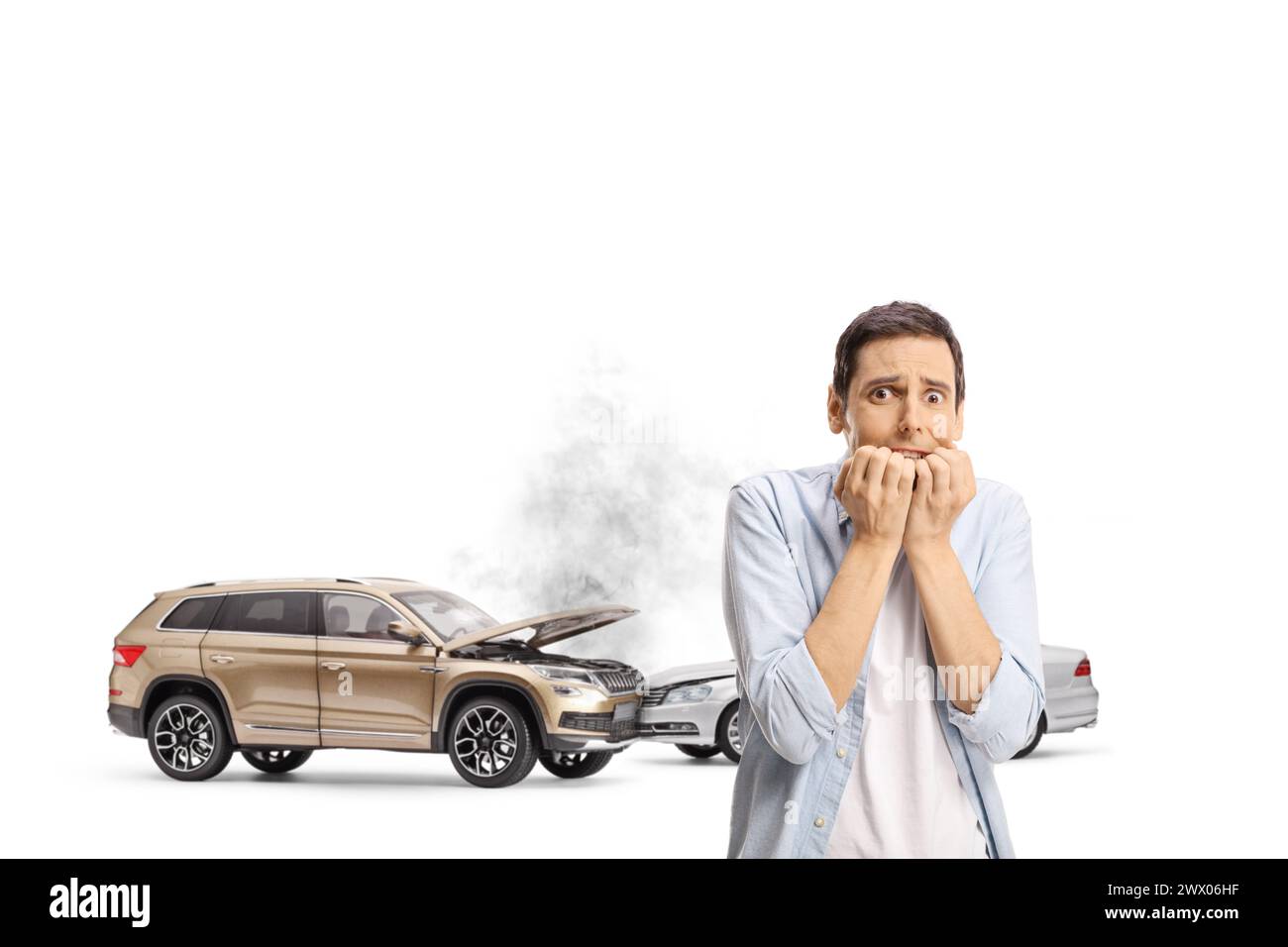 Scared young man in front of a car crash isolated on blue background ...
