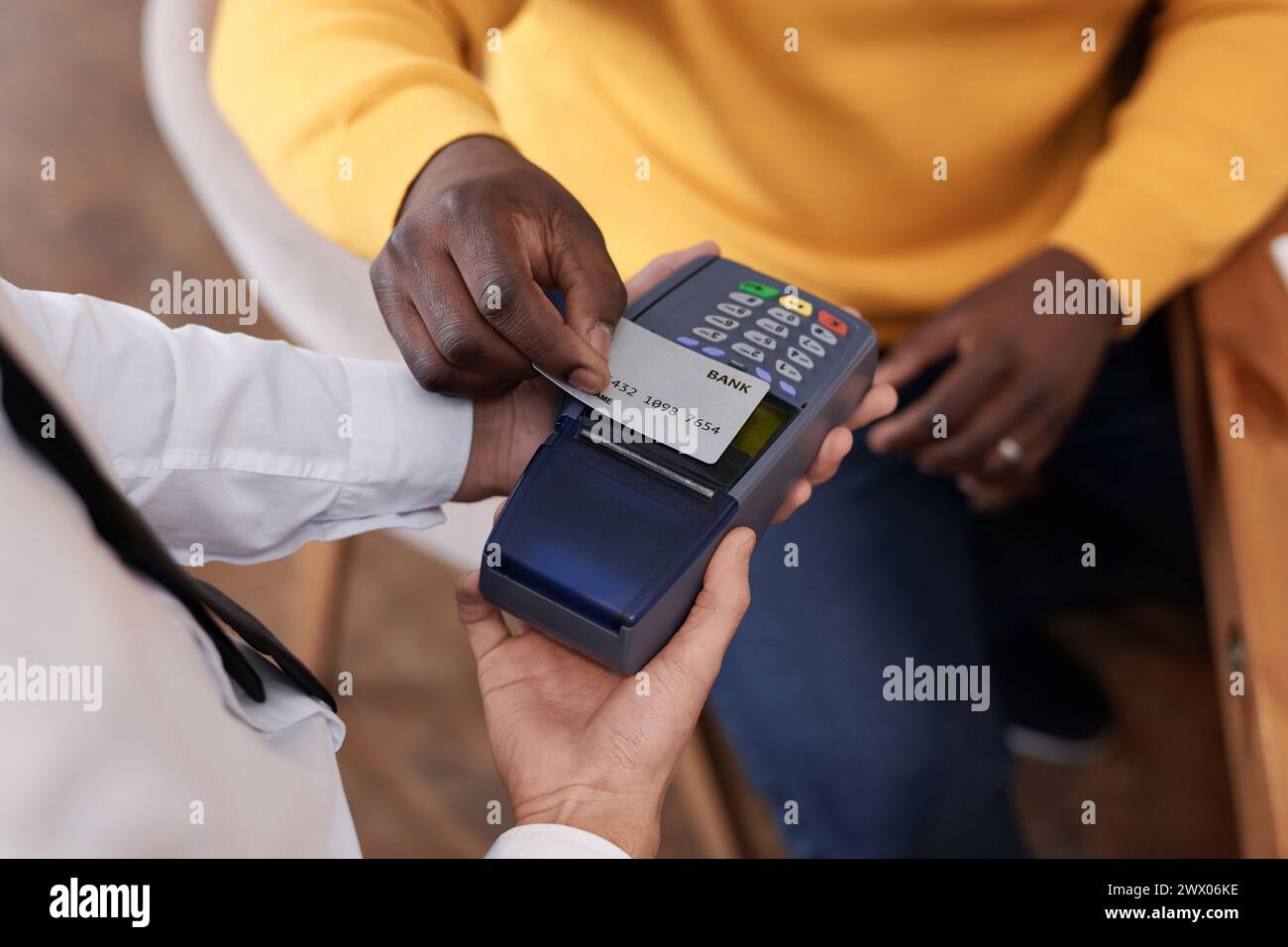 High angle view closeup of unrecognizable Asian waiter holding payment ...