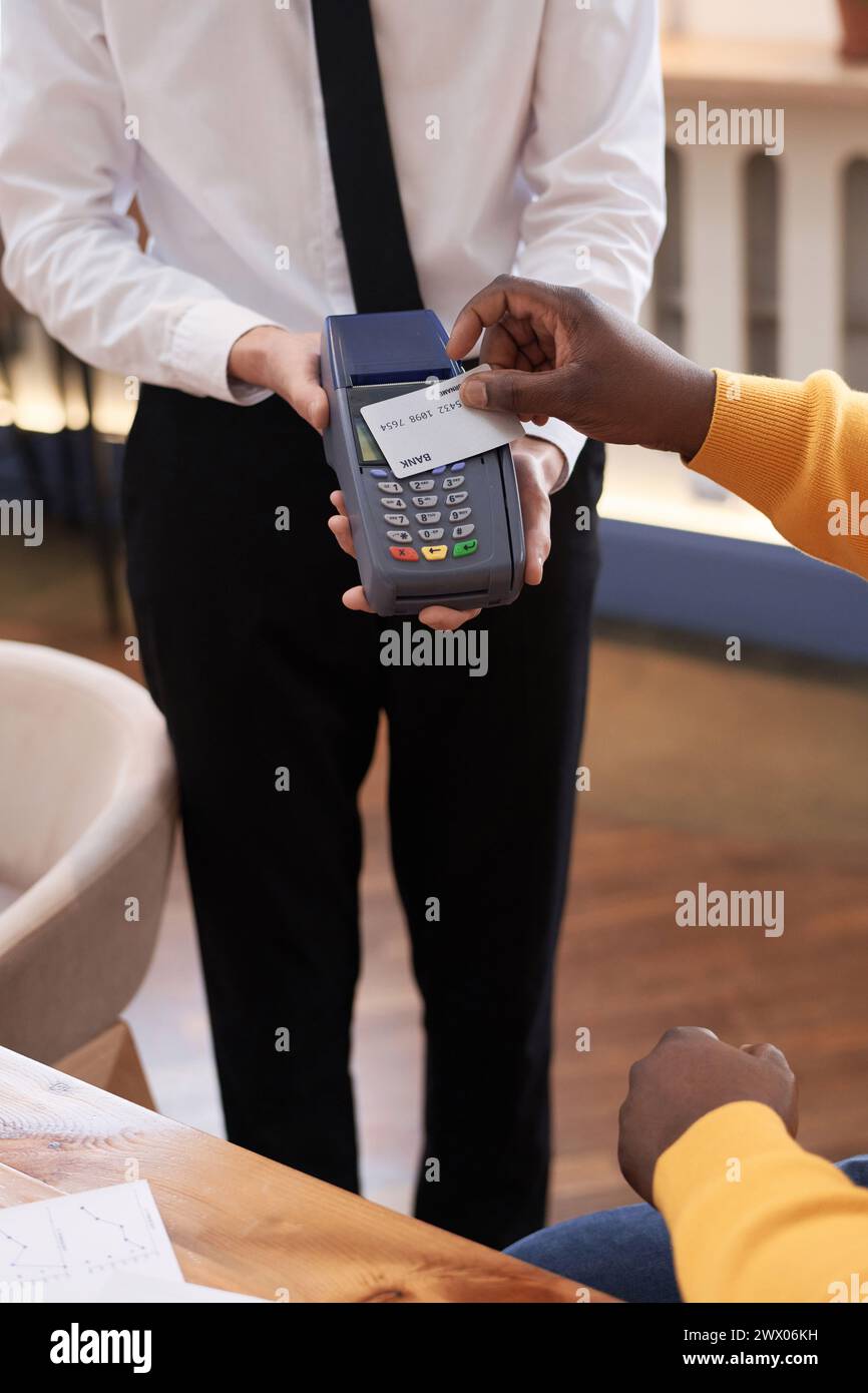 Vertical shot of unrecognizable Black man paying for order in ...