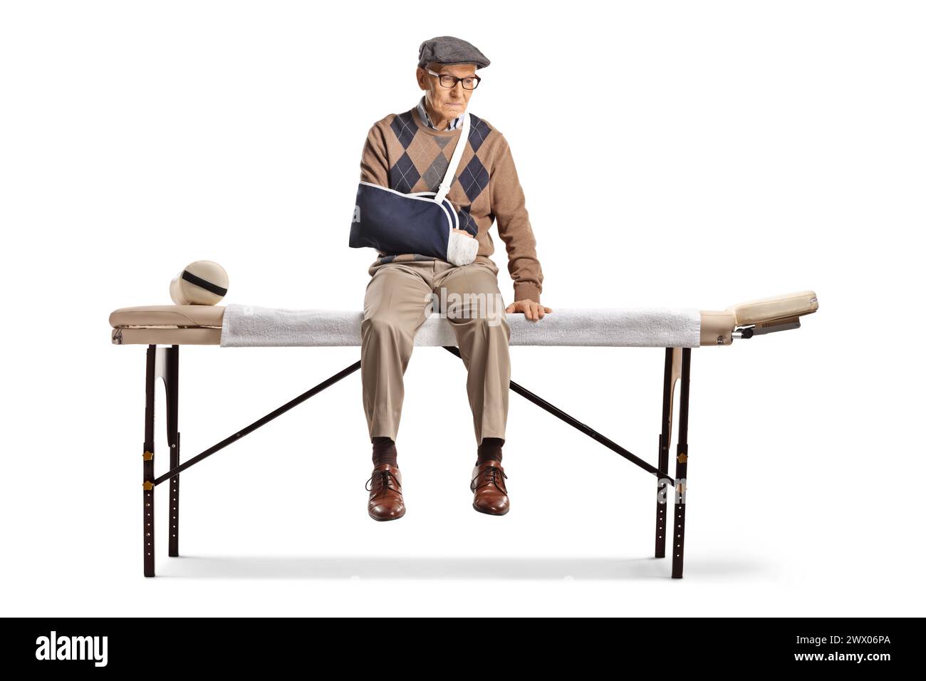 Sad elderly man with a broken arm sitting on a medical bed isolated on ...