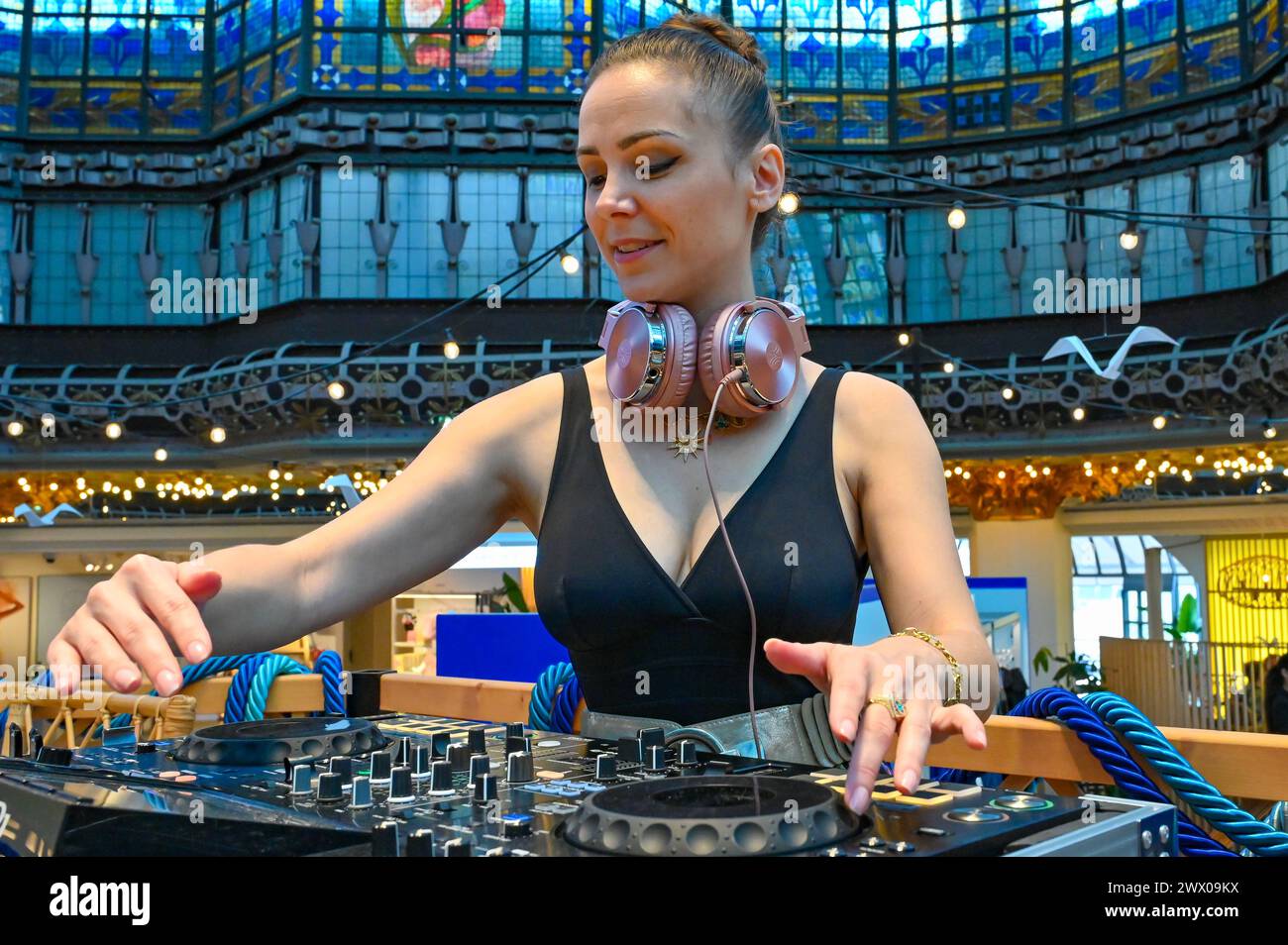 Beautiful young female DJ performing in Galleries Lafayette, Paris ...