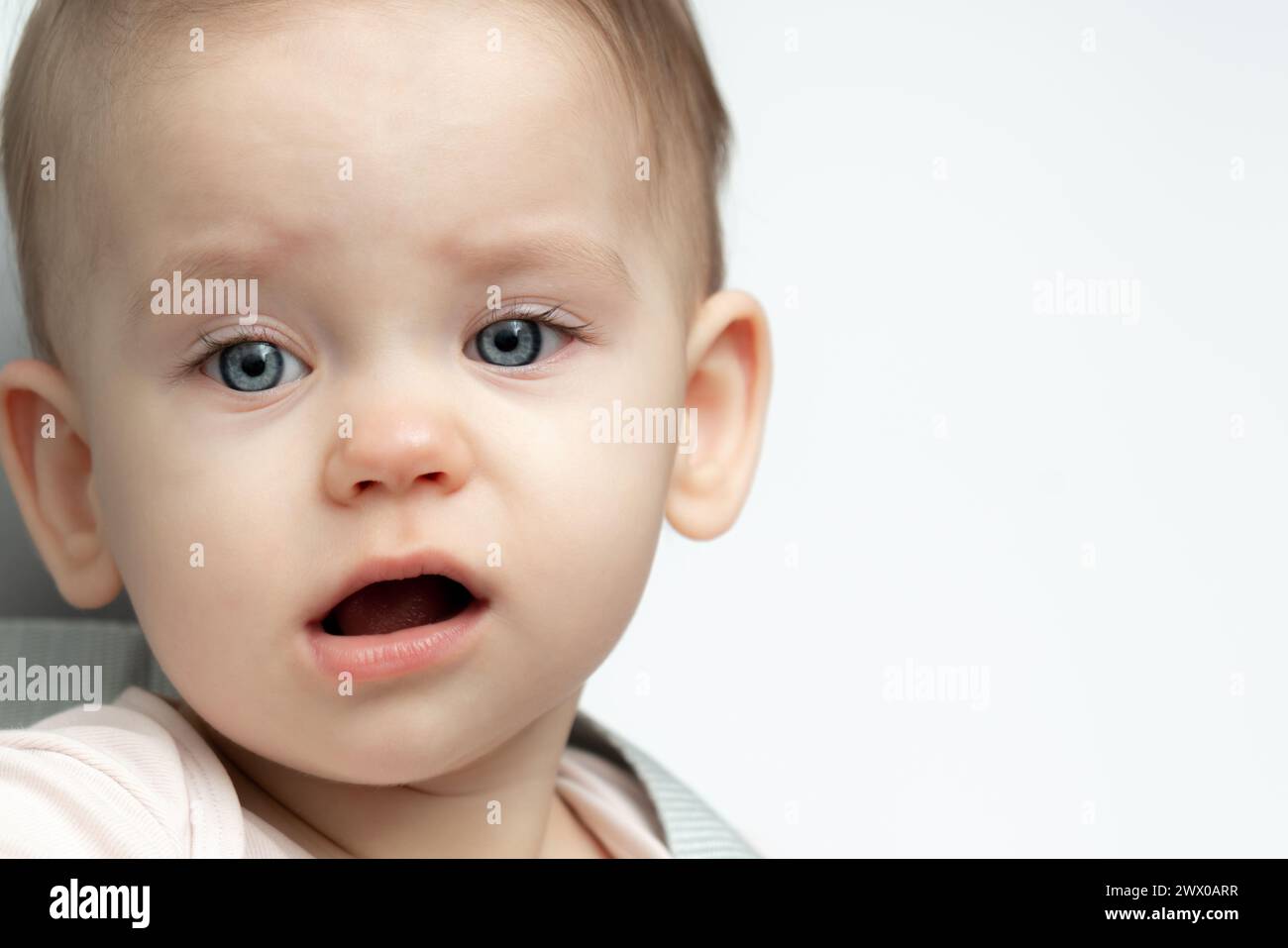 a baby is crying while sitting in a chair Stock Photo - Alamy