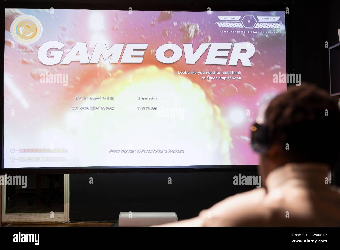 Gamer wearing headphones upset at seeing game over message on ...