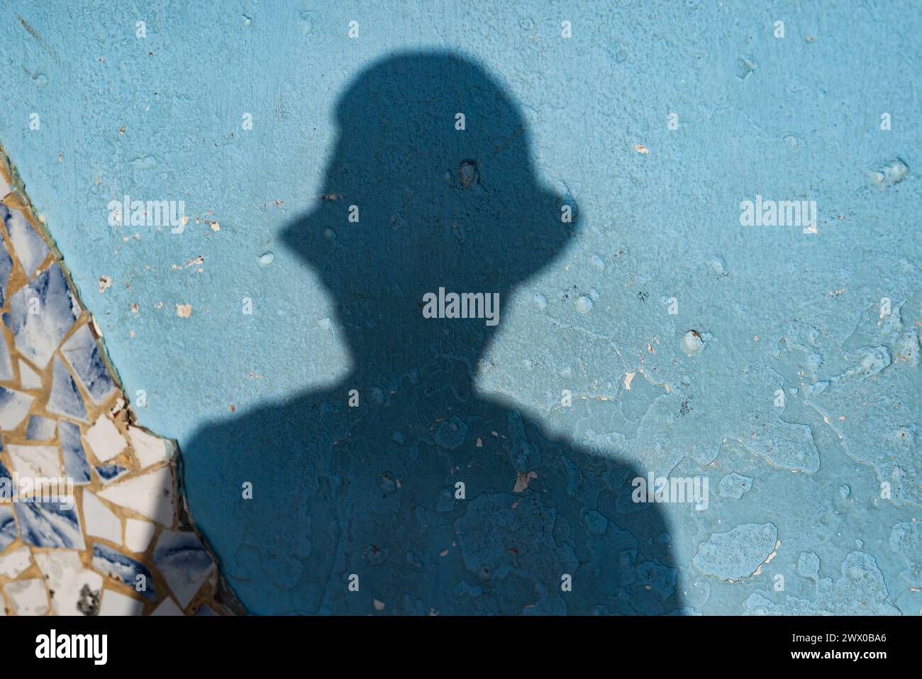 Shadow on the wall of an unidentified person wearing a hat. Texture ...