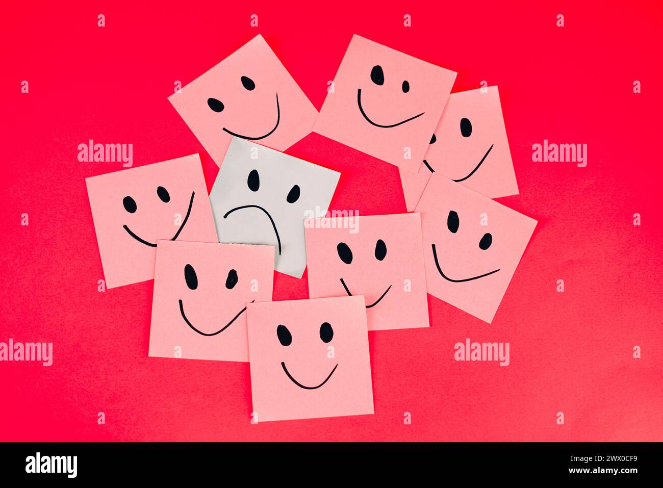 Pink smiling sticky notes and one sad sticky note. Concept of ...