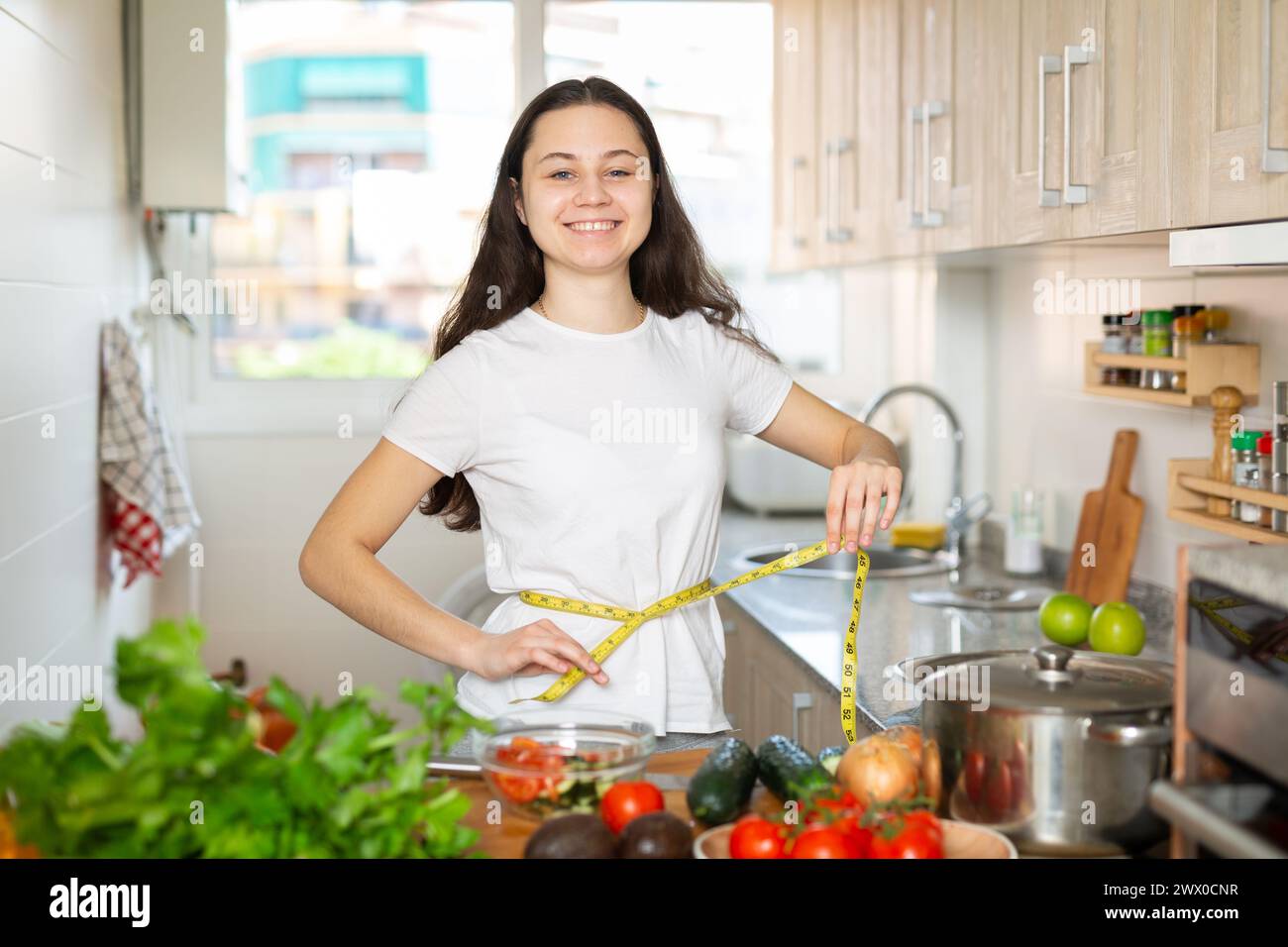 Young pretty girl measuring her waist with measuring tape Stock Photo ...