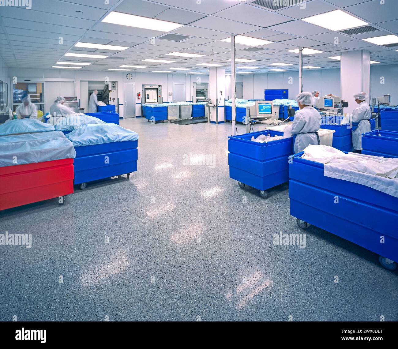 Workers are gowned up to work in clean rooms. There are blue and red ...
