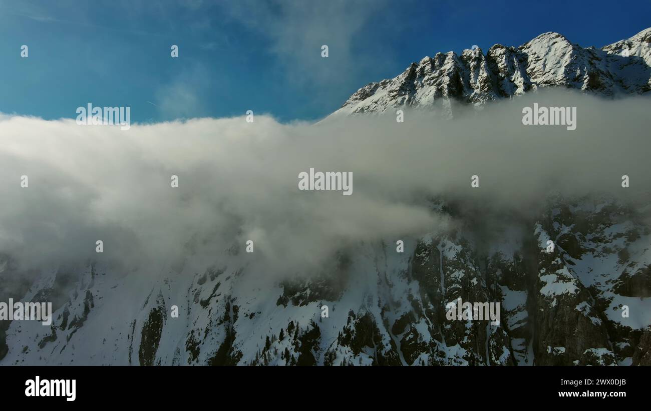 Flying through clouds between mountains Stock Photo - Alamy