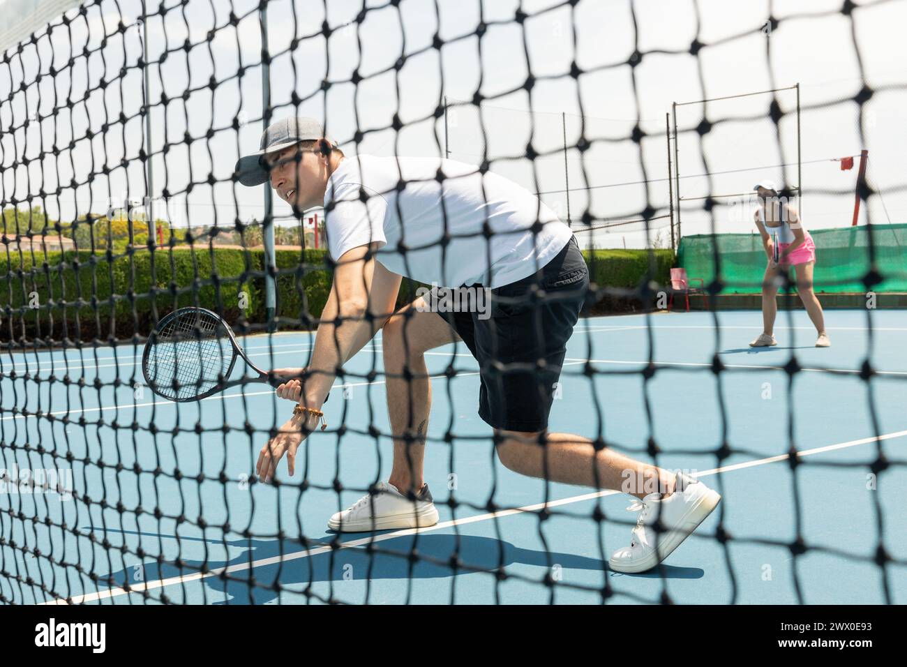 Portrait of man playing with male partner tennis doubles game on ...