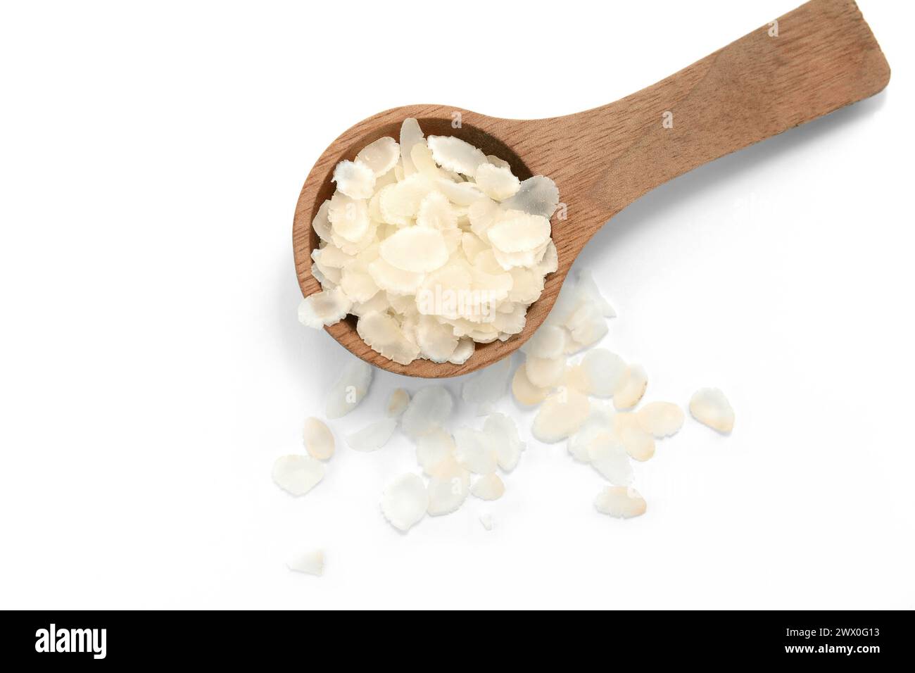 flattened rice flakes in a wooden spoon isolated on white Stock Photo ...