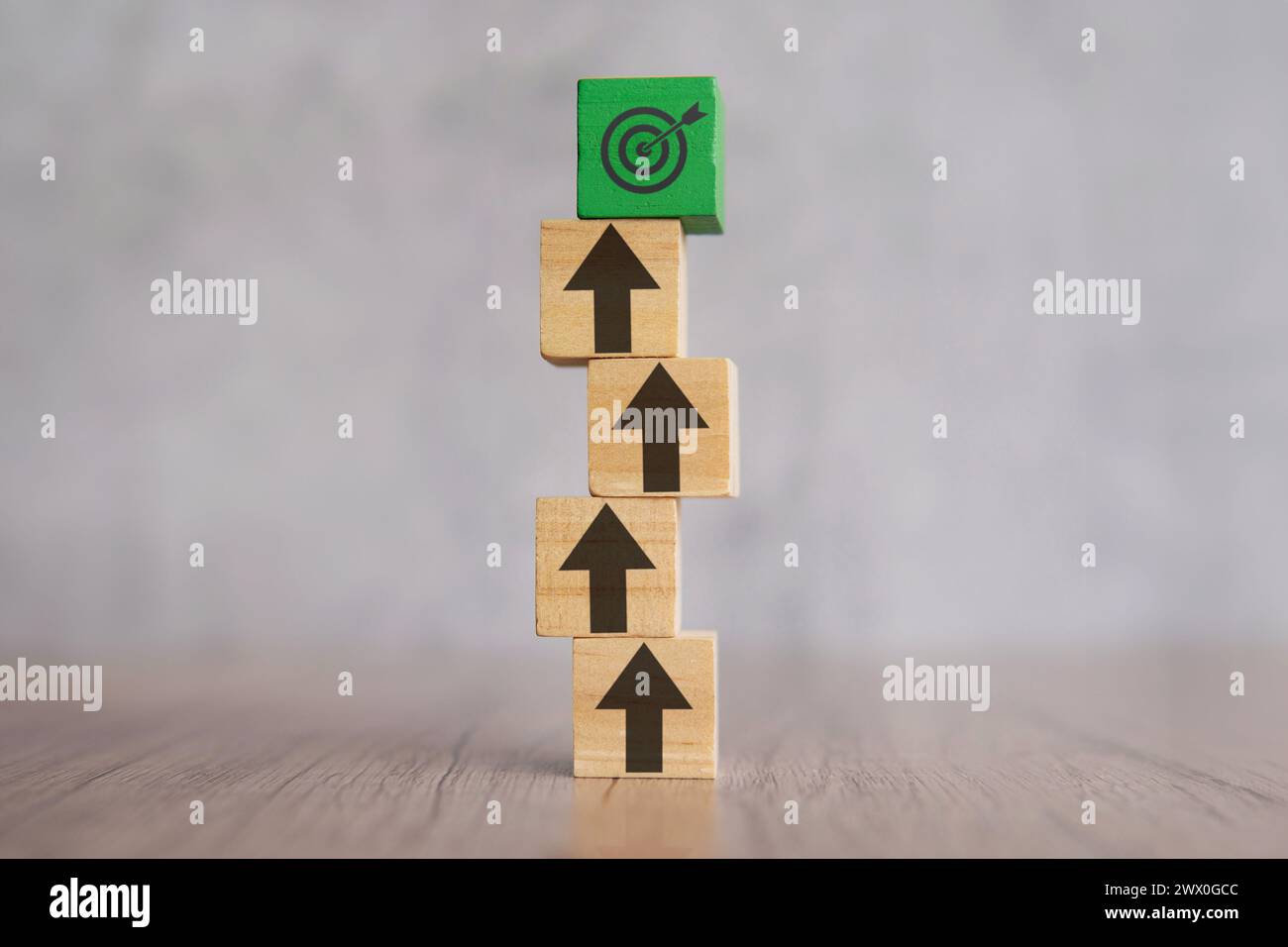 A stack of wooden blocks with arrows pointing upwards and target board ...