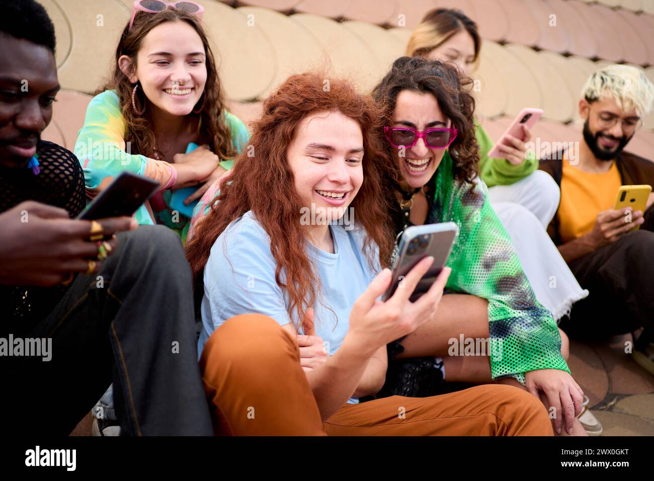 Side view large multiracial group young friends using cell phones ...