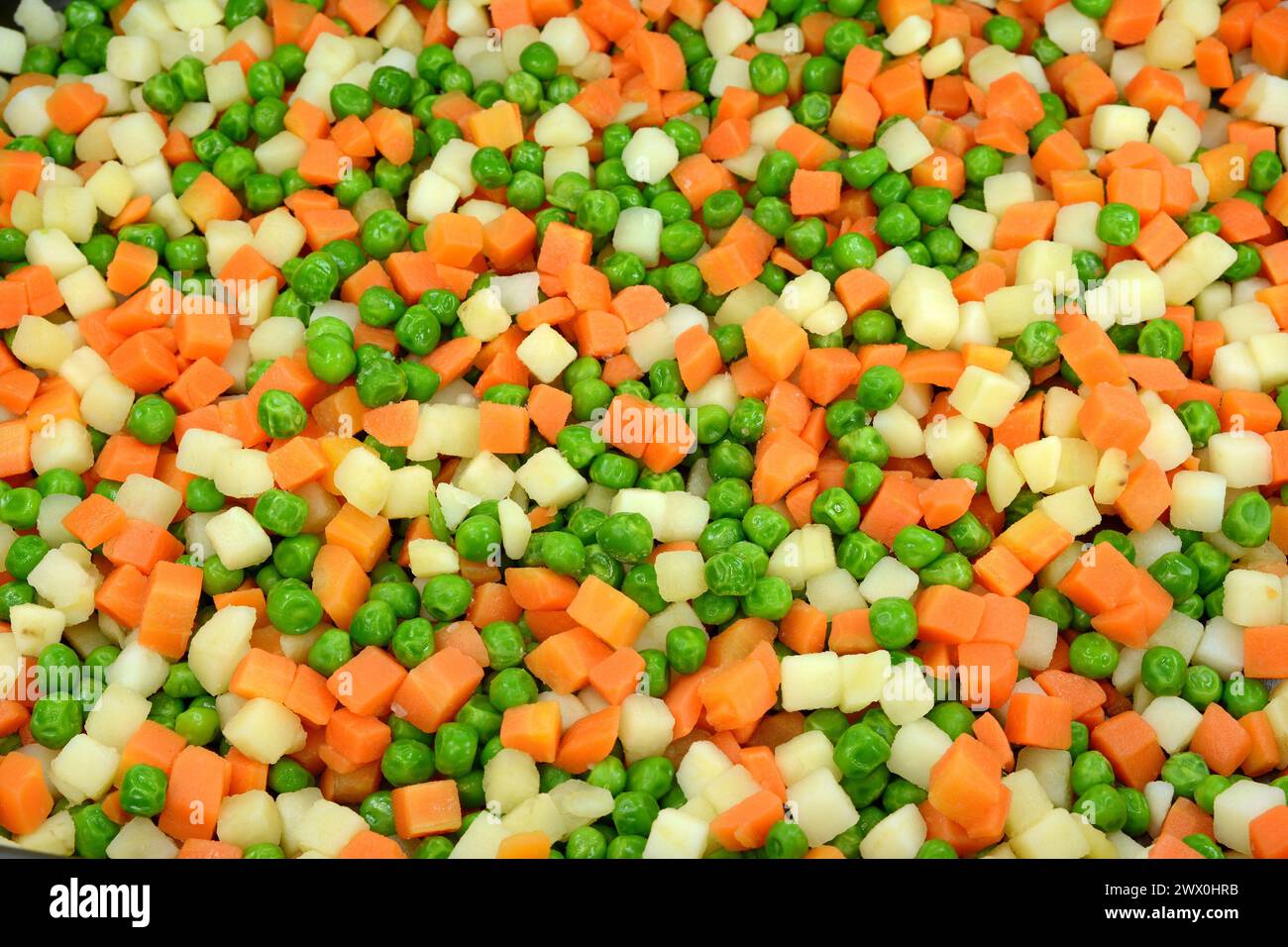 Raw diced vegetables including carrot peas potato and peas background ...
