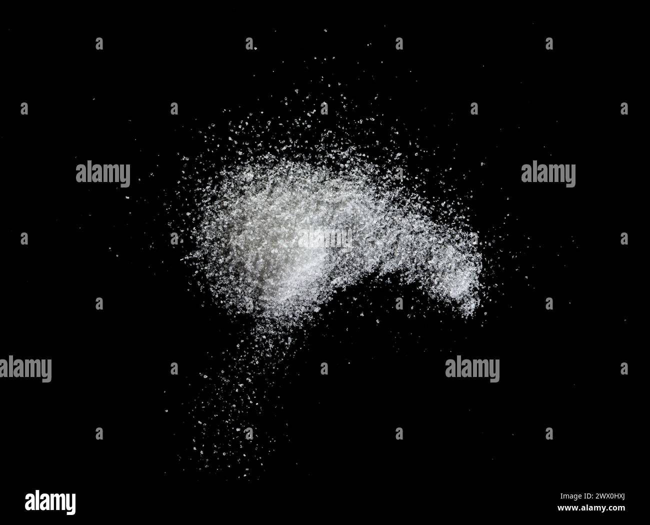 Spilled white sea salt on a black background. clear crystalline pebbles ...