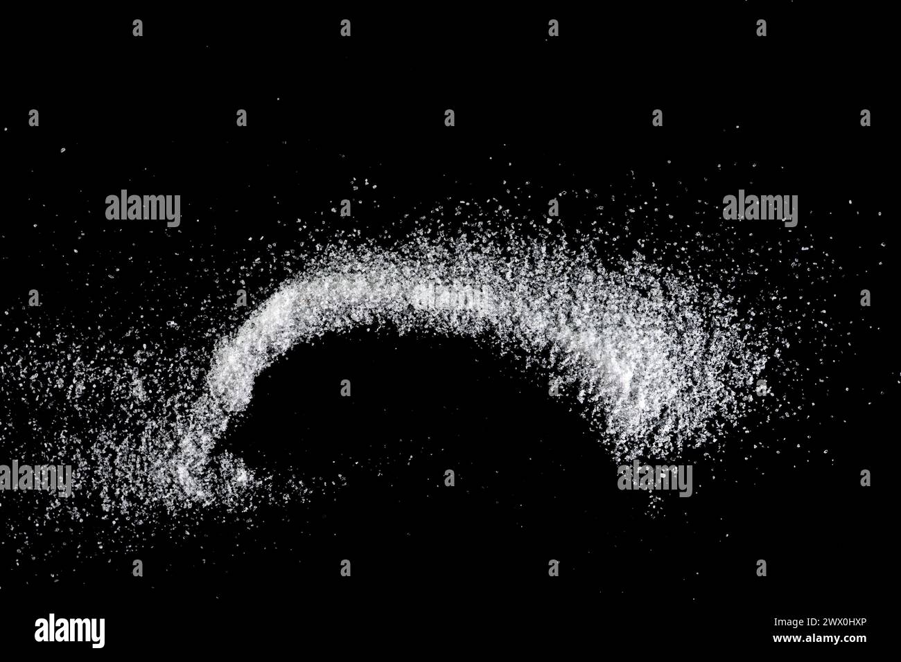 Spilled white sea salt on a black background. clear crystalline pebbles ...