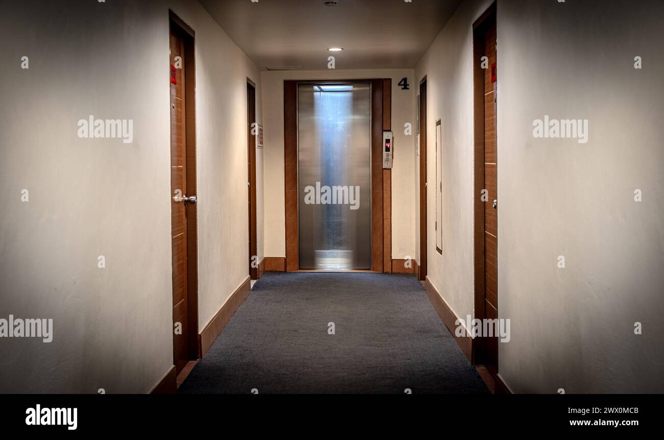 At the end of the corridor, the elevator doors are opening Stock Photo ...