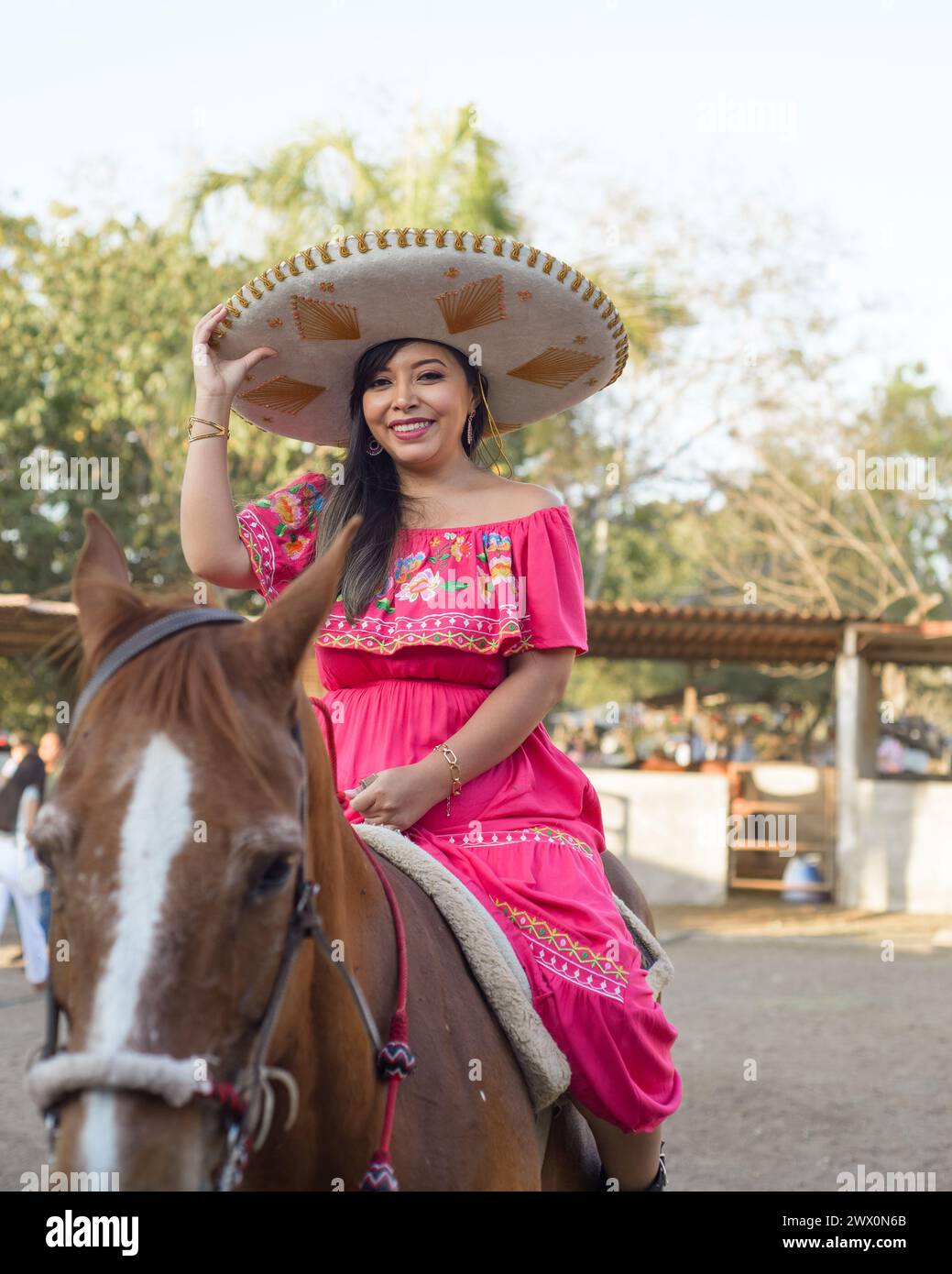 Mexican woman wearing traditional dress and charro hat on horseback ...
