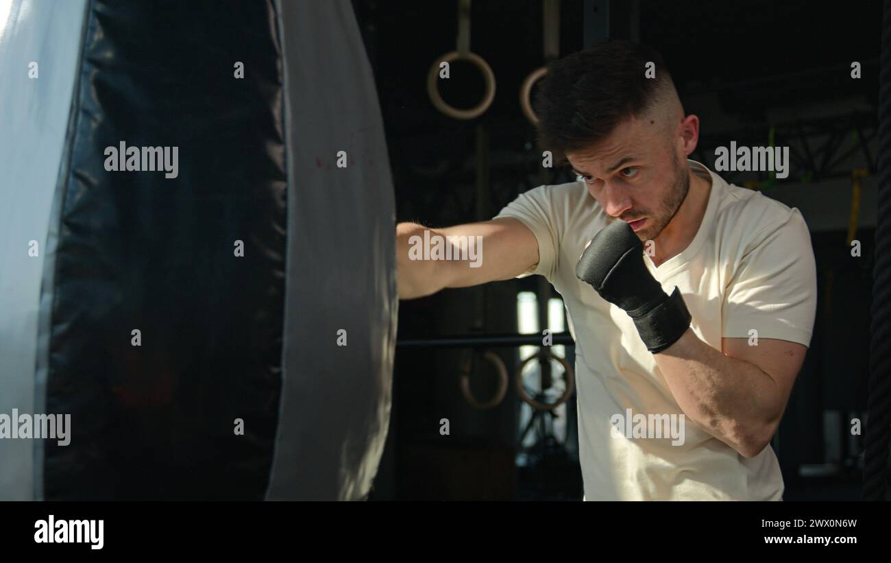 Male sportsman Caucasian man boxer training with punching bag boxing ...