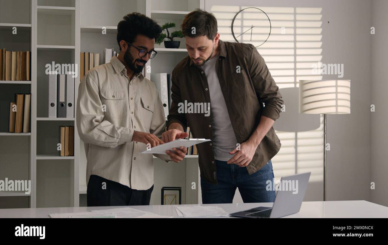 Two multiethnic colleagues businessmen business coworkers at office ...