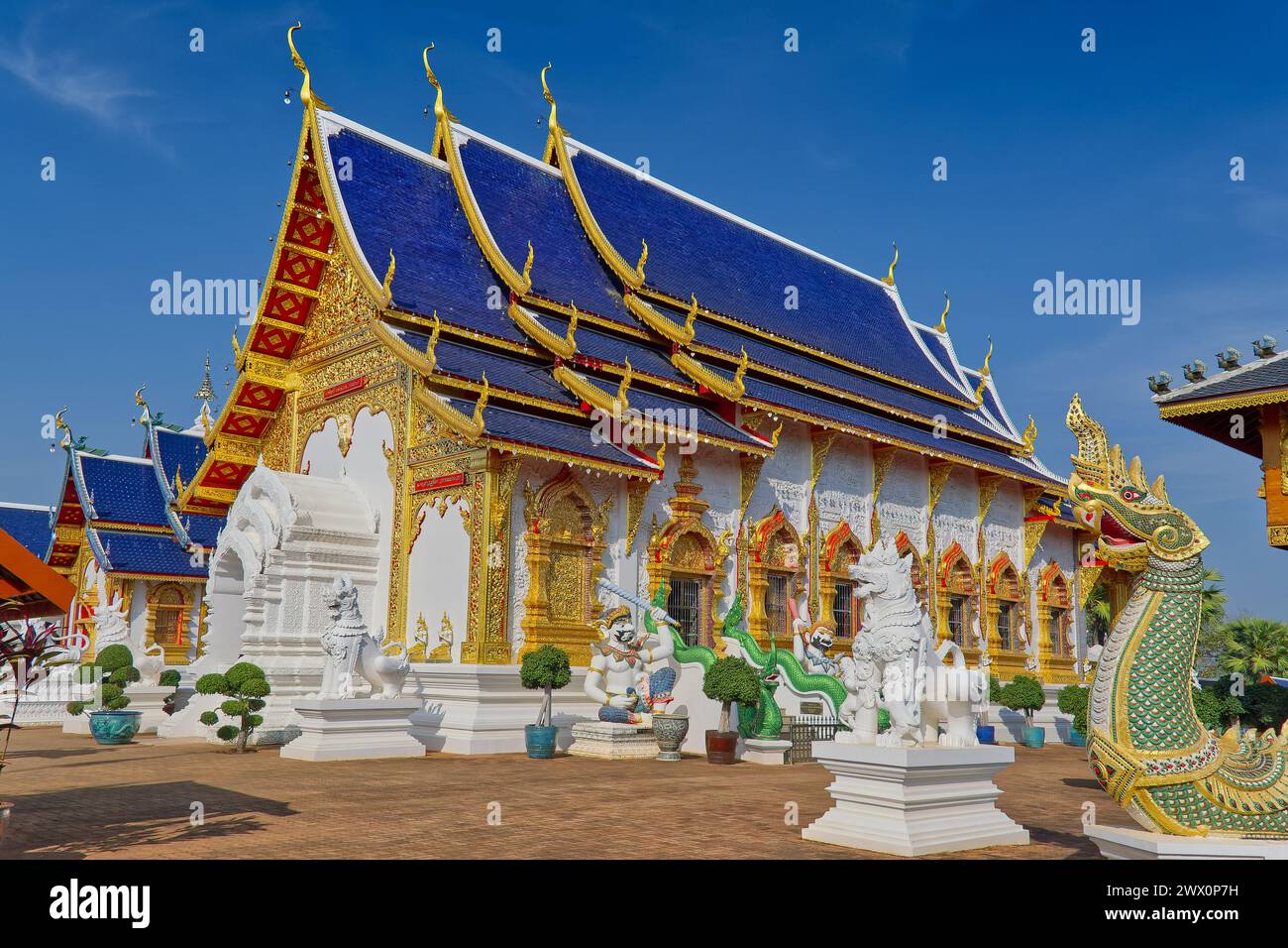 A heavily decorated blue roofed, white Viharn at Wat Ban Den, Inthakin ...