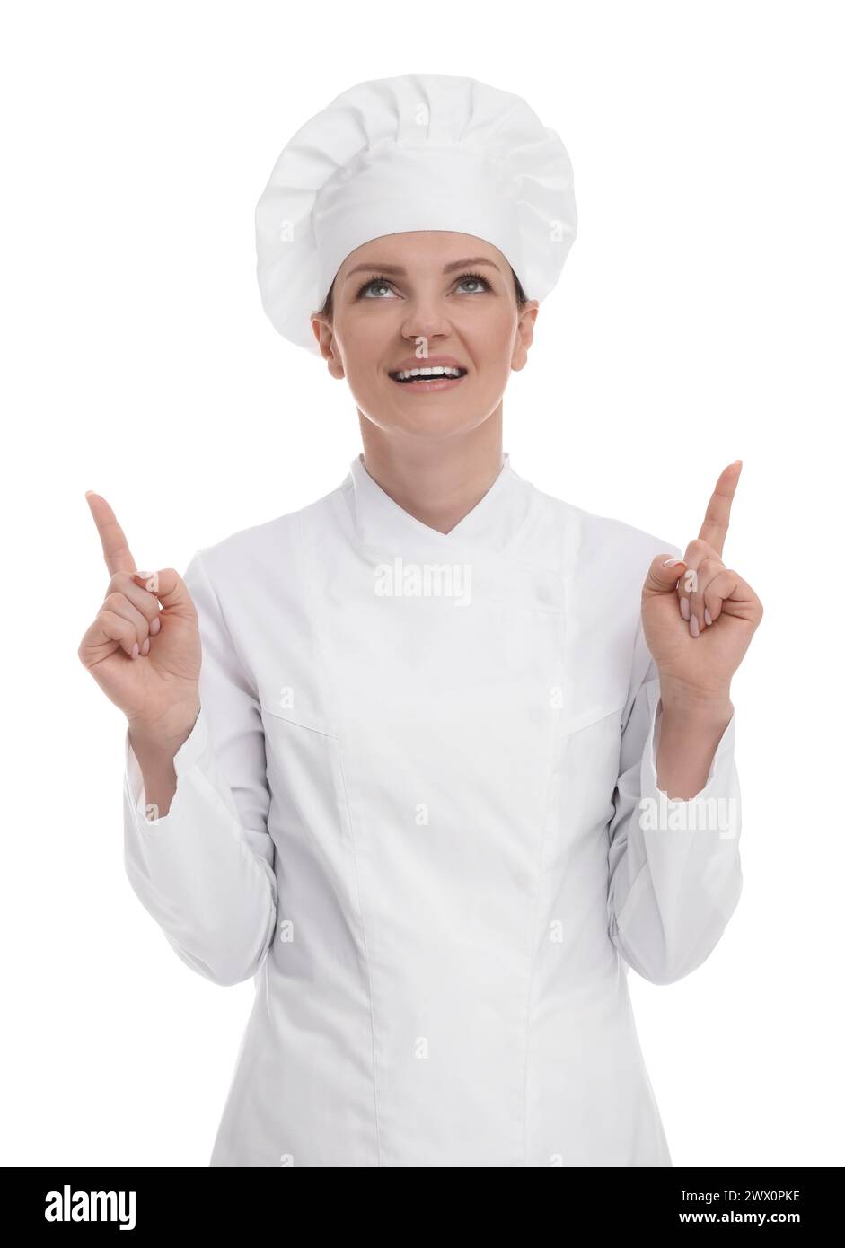 Happy woman chef in uniform pointing at something on white background ...