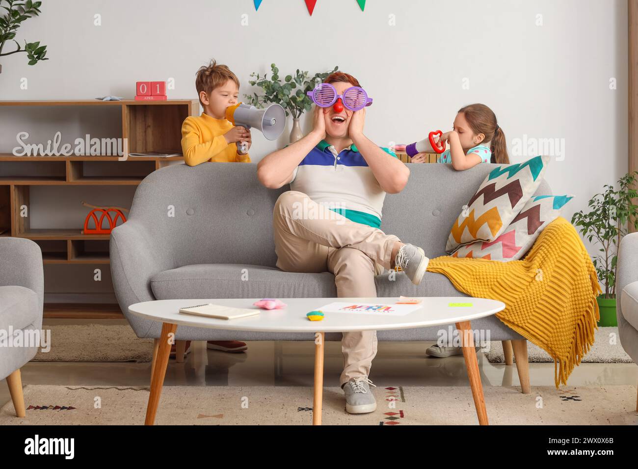 Little children surprising their father with megaphones, funny disguise ...