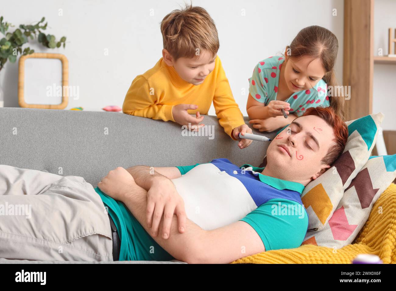Little children painting face of their sleeping father at home. April ...