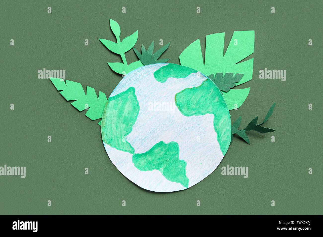 Paper planet Earth with green felt leaves on green background. Earth ...