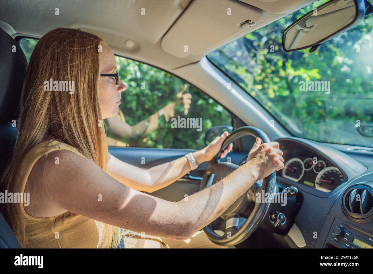 Pregnant woman driving with safety belt on in the car. Confident and ...