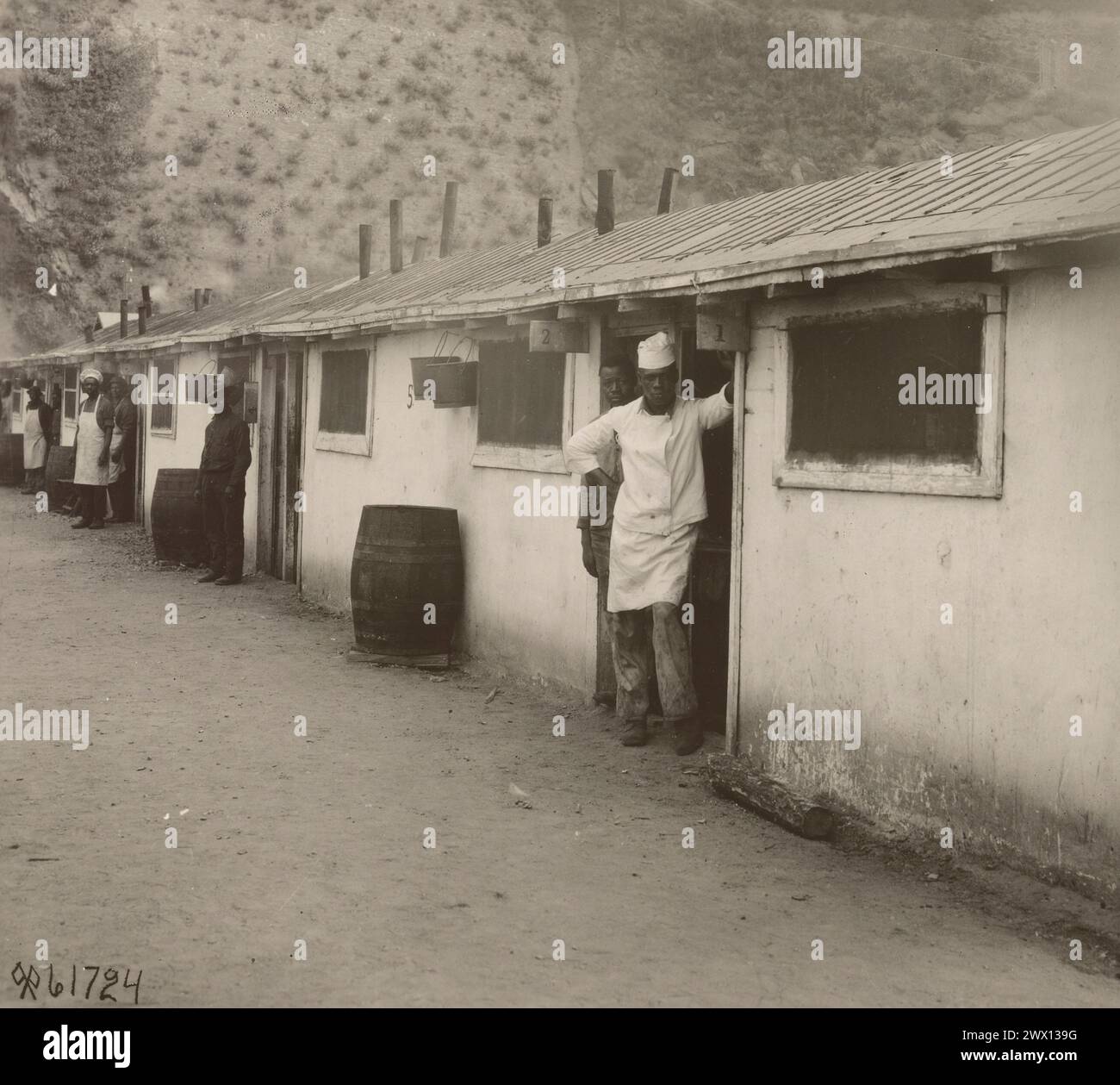 African American cooks stand outside camp cooking shacks in France ca ...