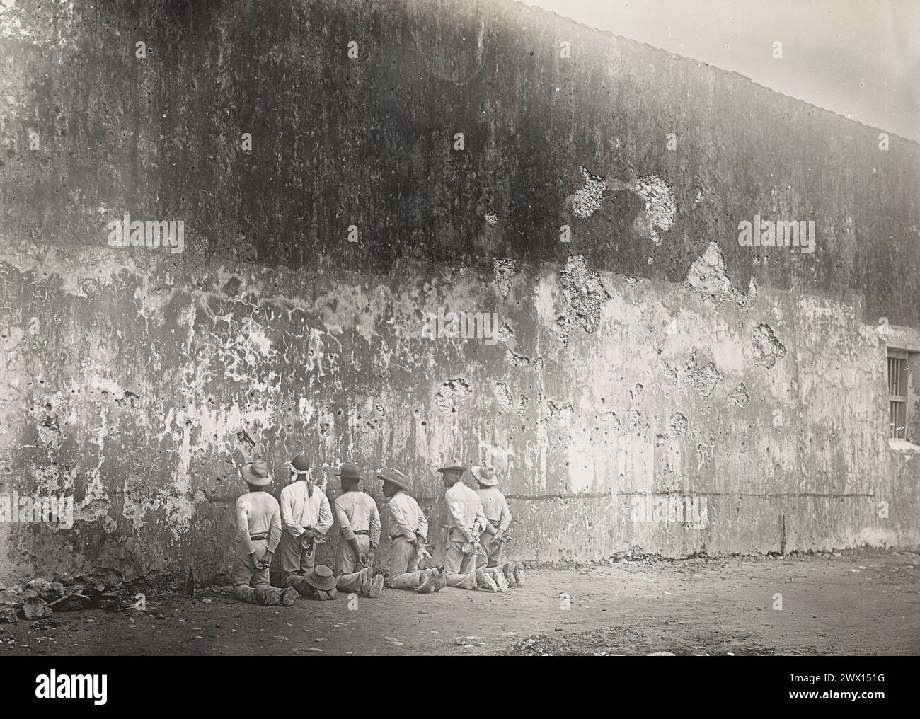 Dead line at the arsenal, Santiago, prisoners lined up against a stone ...