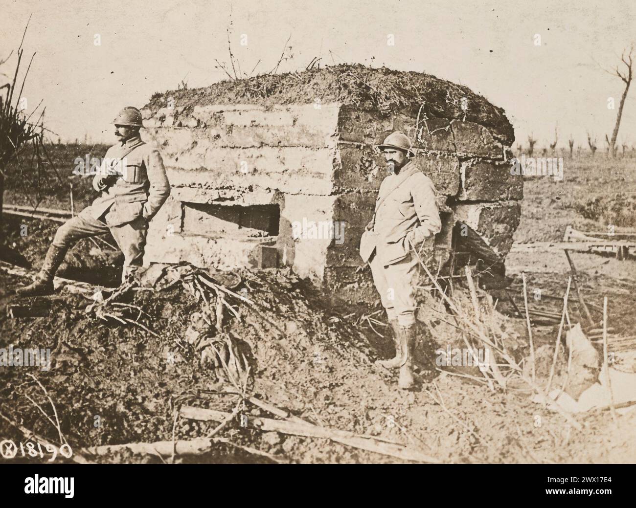 Two soldiers stand next to one of the numerous blockhouses lost by the German Army in Flanders ...