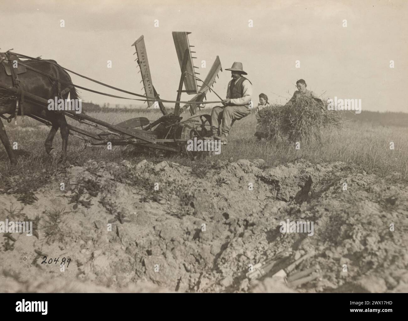 Farmers reaping wheat with an American harvesting machine on a Marne ...