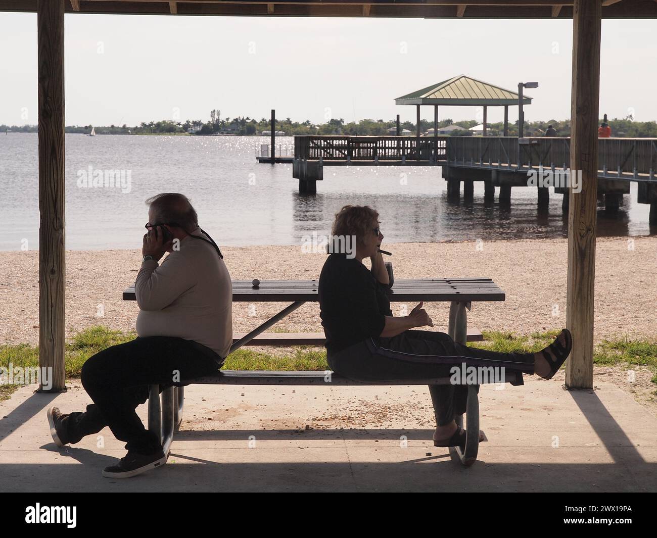 Couple using seperate cell phones on a picnic table hi-res stock photography and images - Alamy