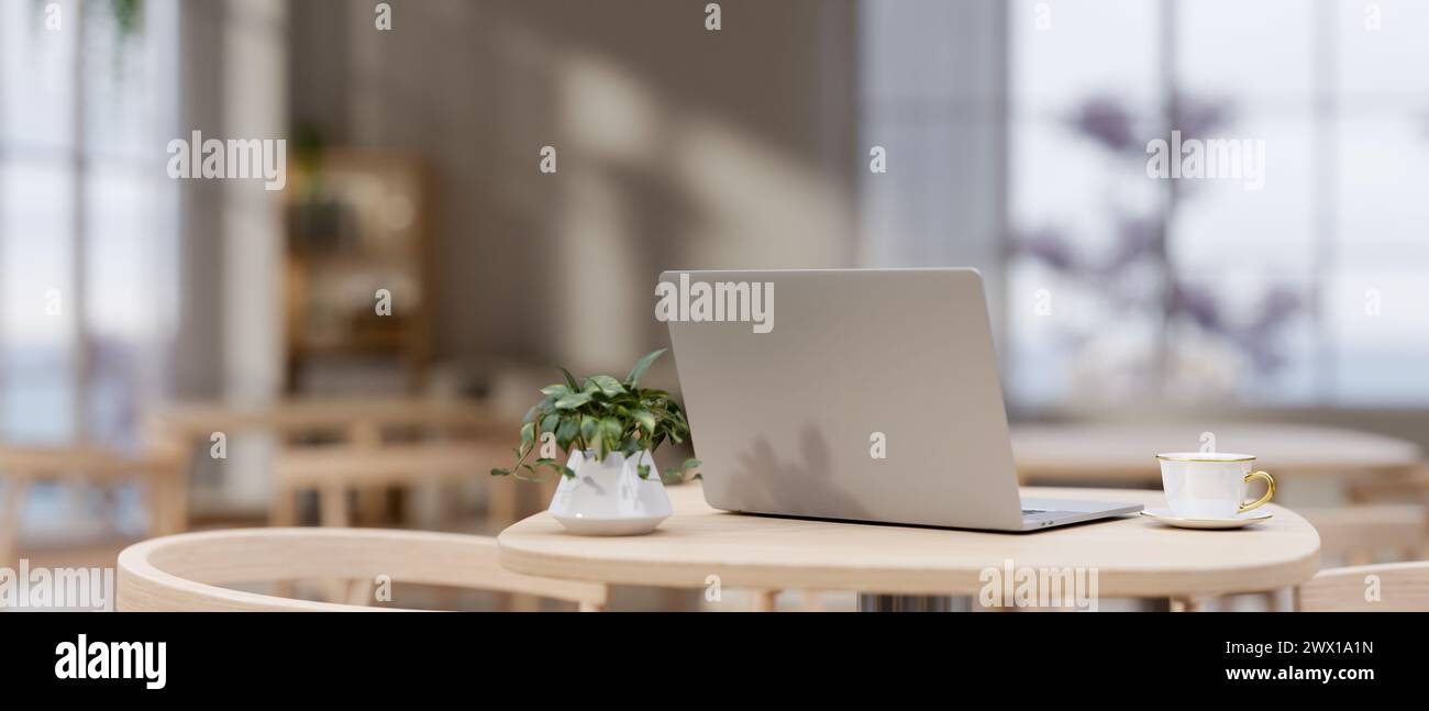 A back view image of a laptop computer on a wooden table in a modern ...