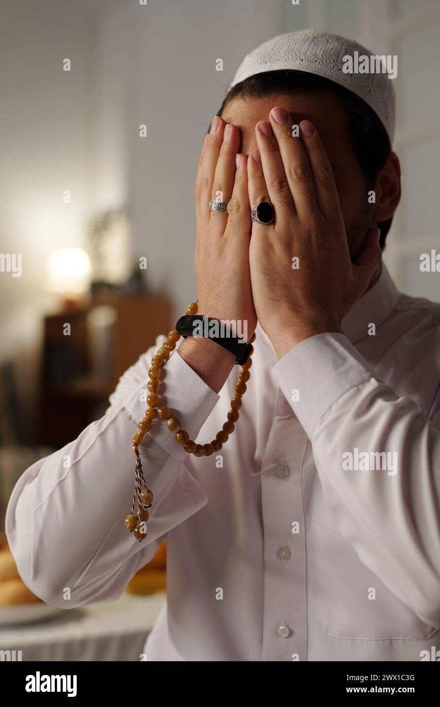 Vertical medium closeup of unrecognizable young Muslim man wearing ...