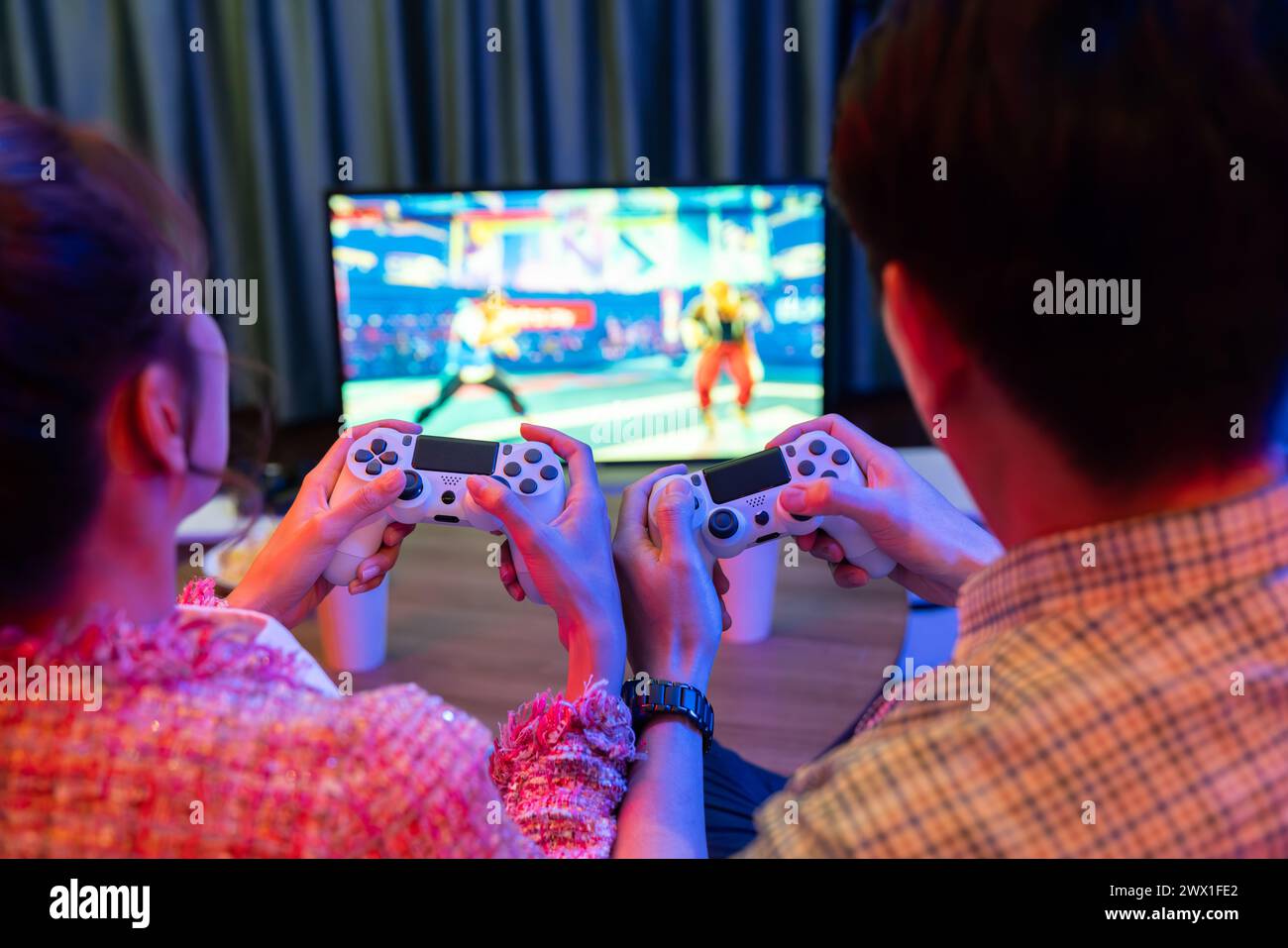 Couple gamer with controlled joystick playing fighting competition ...