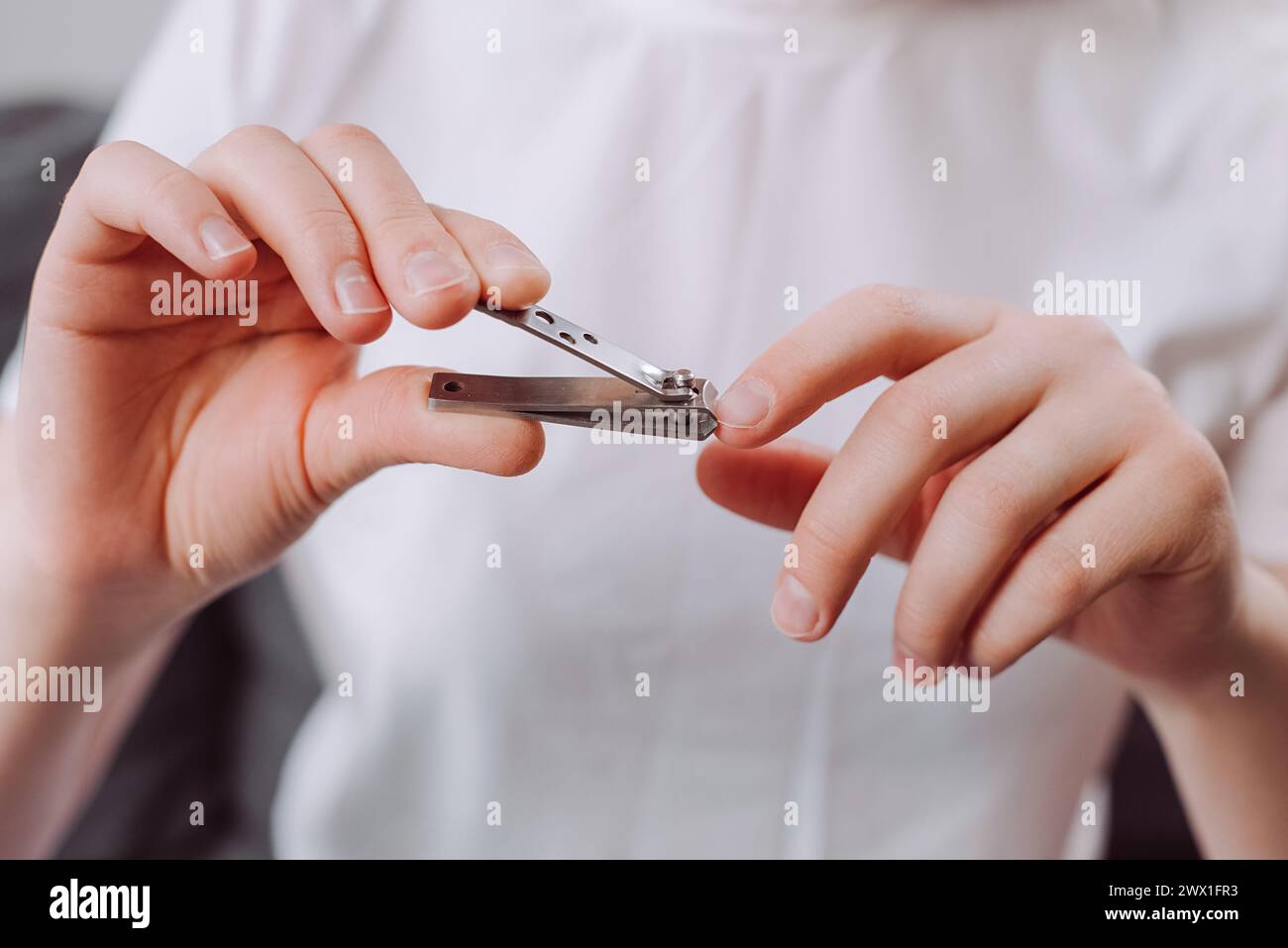 Female hands manicure with nail clipper cutting fingernail on long or ...