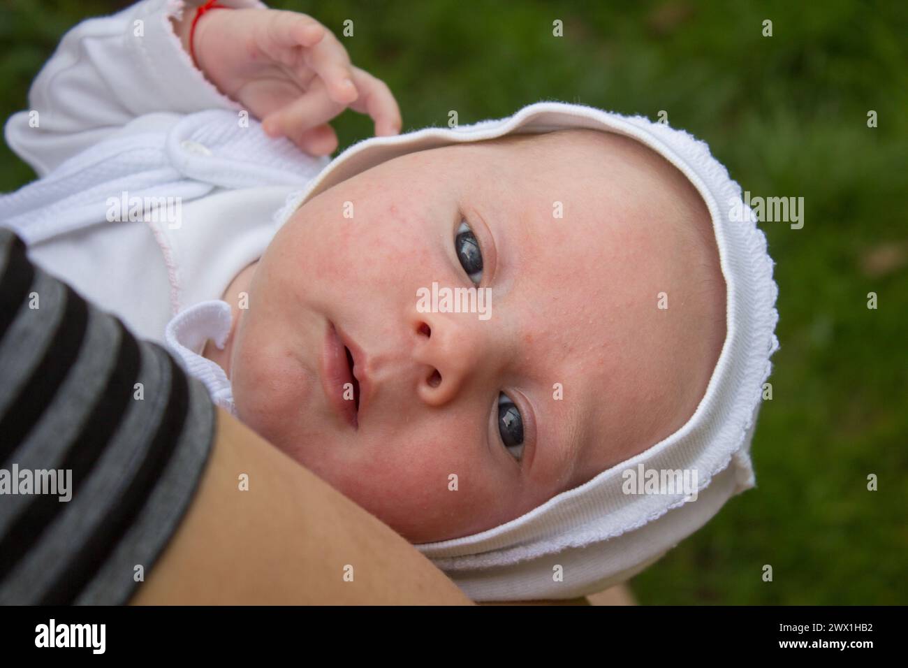 A newborn baby looks at her mom's back Stock Photo - Alamy