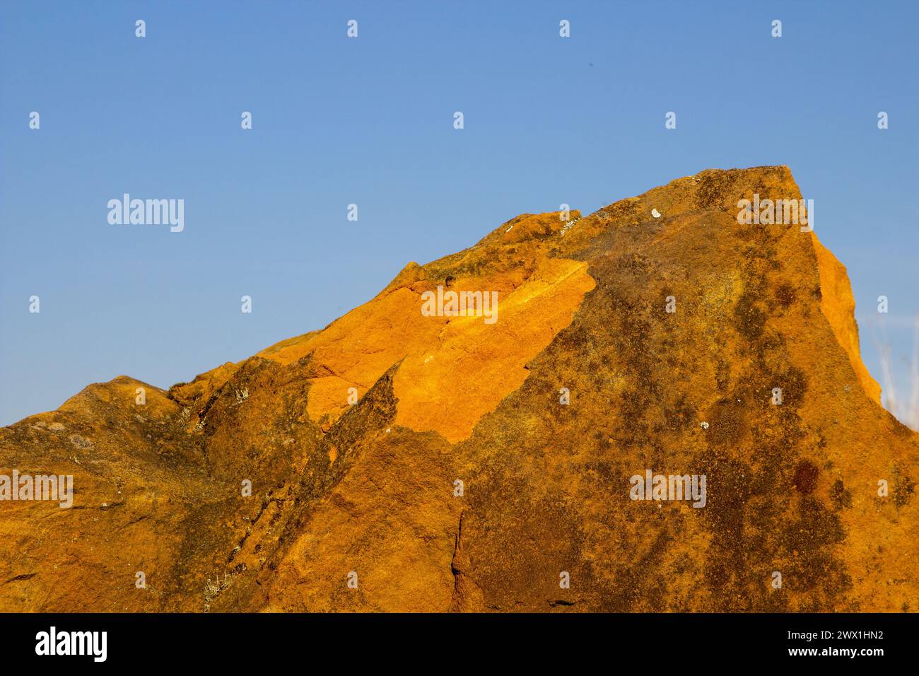 large sandy rock on blue sky background Stock Photo - Alamy