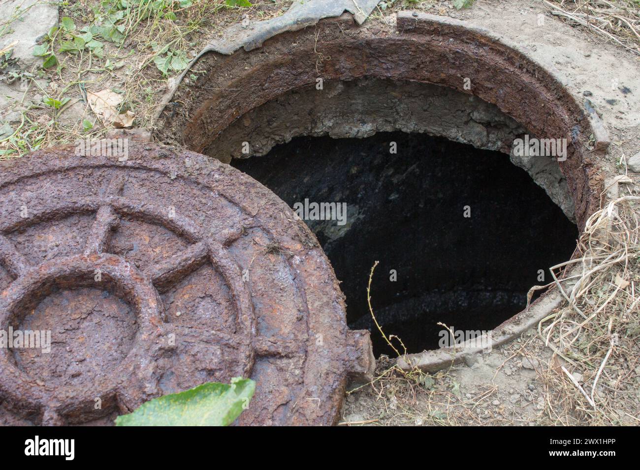 abandoned rusty hatch with open sewerage Stock Photo - Alamy
