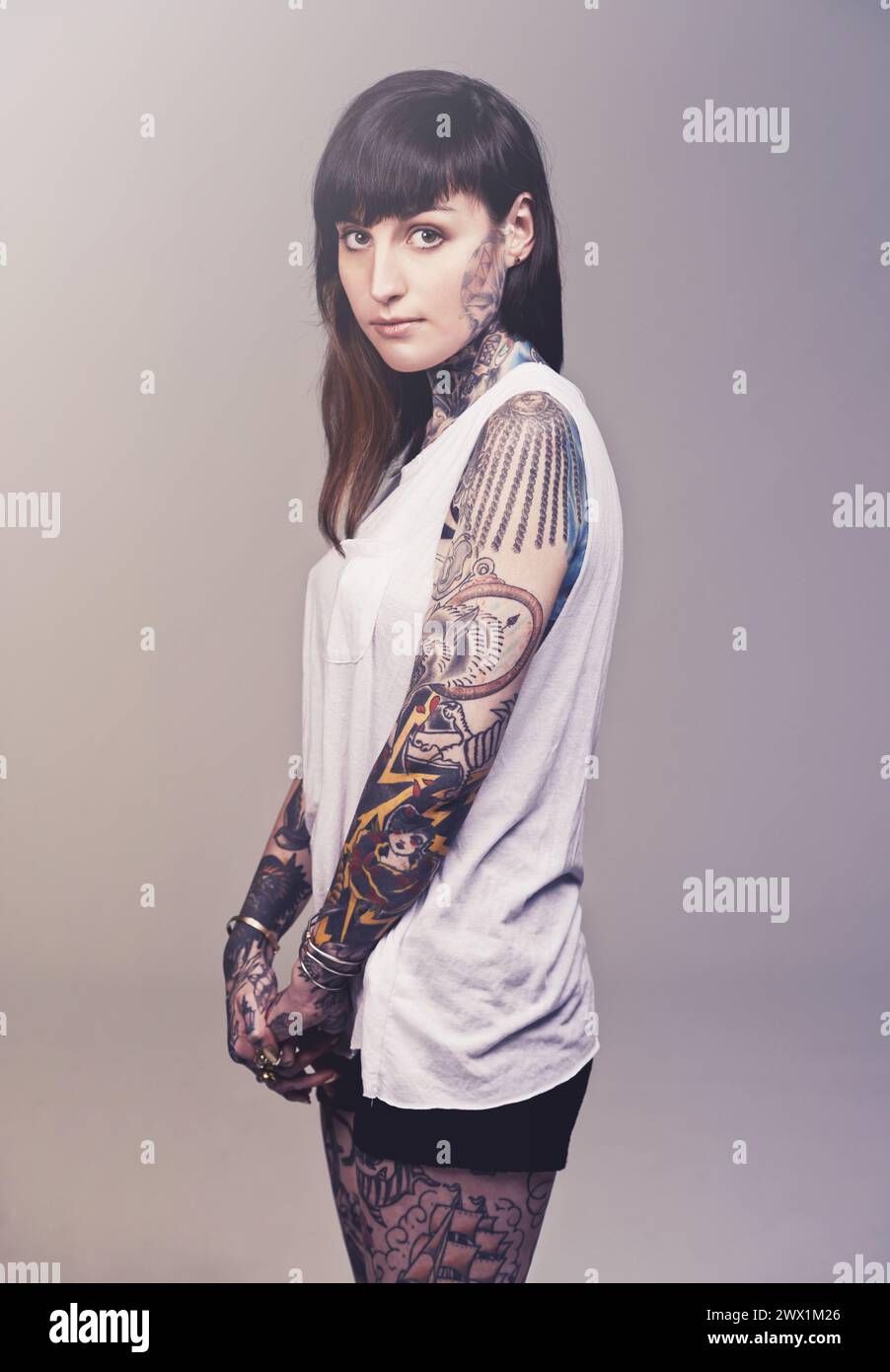 Portrait, culture and woman with tattoos, rebel and punk rock on a grey ...