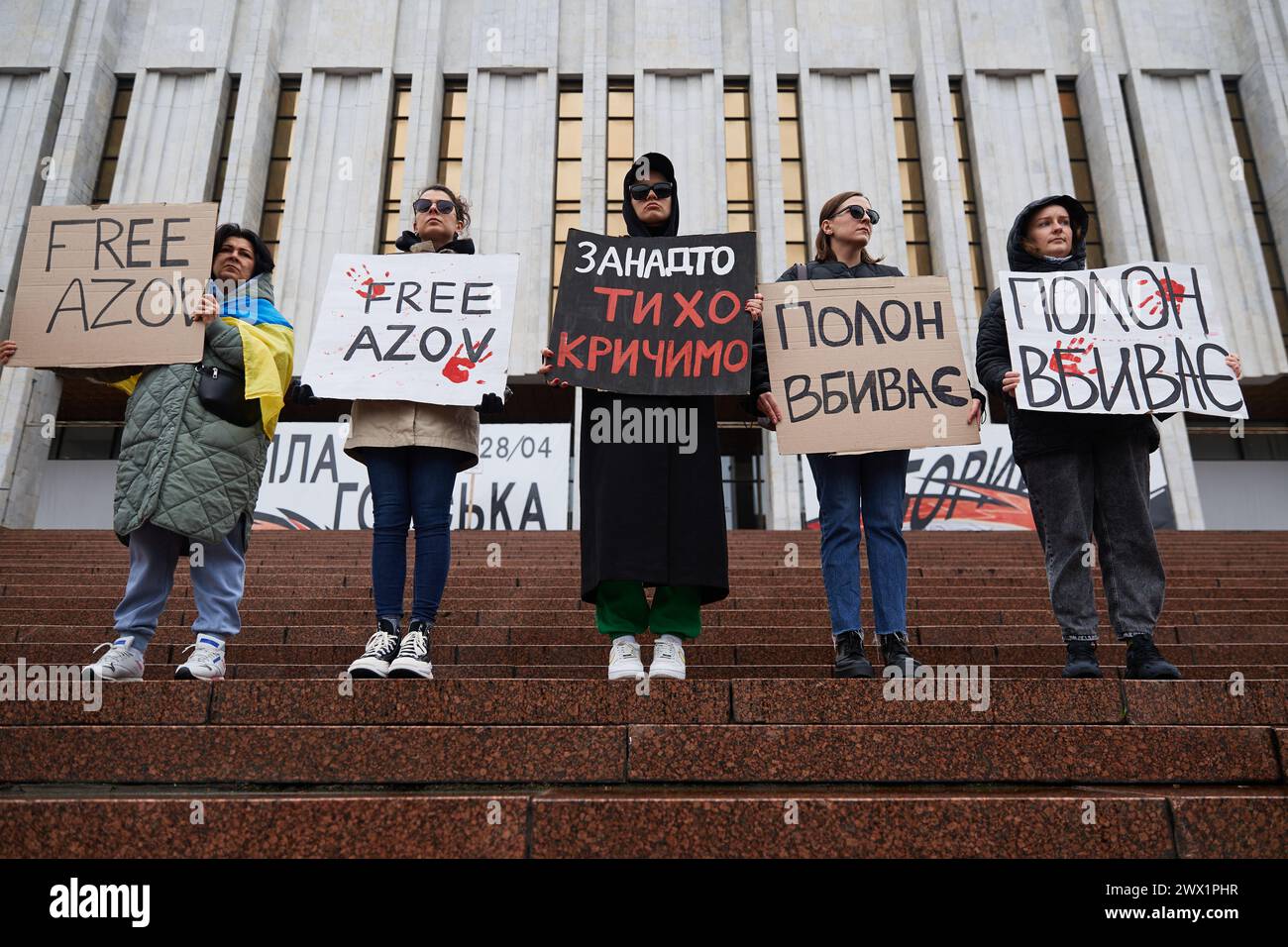 Ukrainian women posing with banners "Free Azov" and "Captivity Kills ...