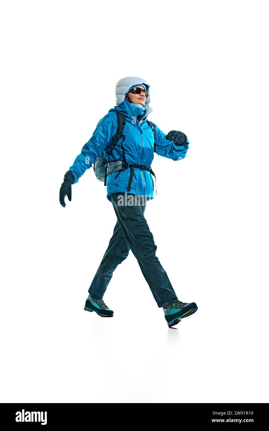 Smiling young woman, tourist wearing jacket, goggles, boots and ...