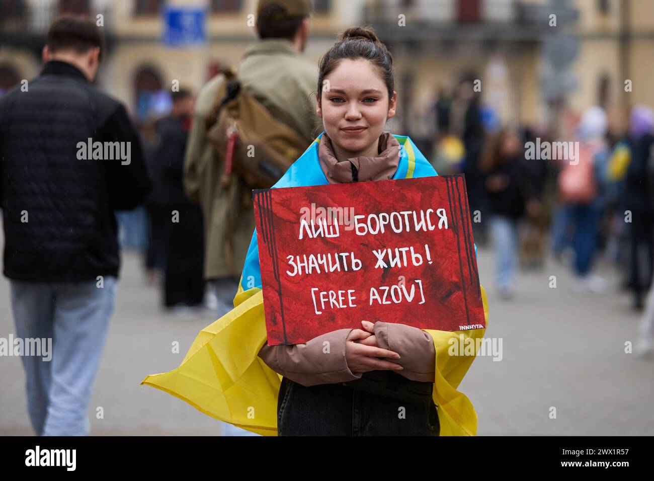 Cheerful Ukrainian girl wearing a national flag on shoulders posing ...