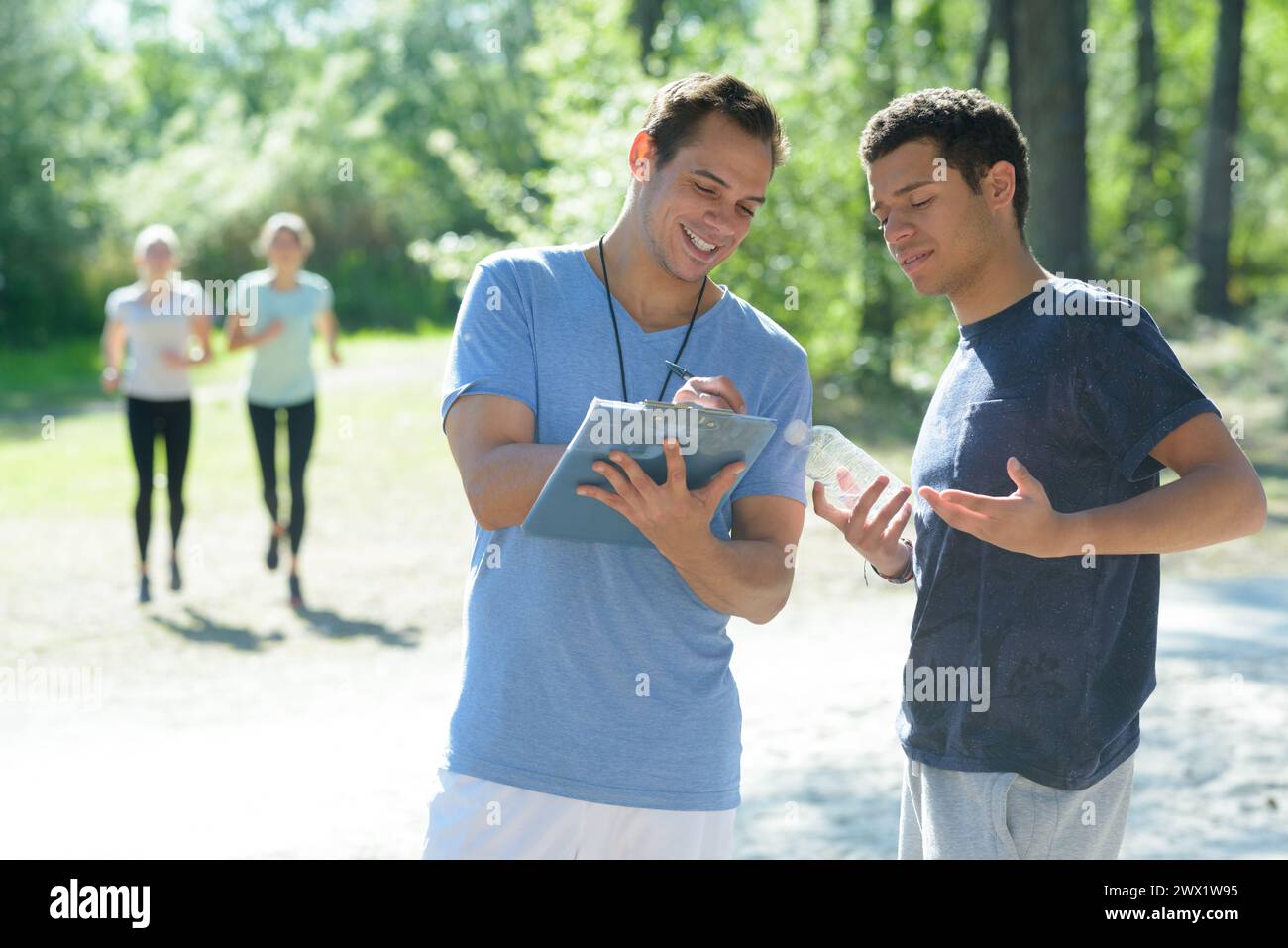portrait of a male fitness instructor holding clipboard outdoor Stock ...