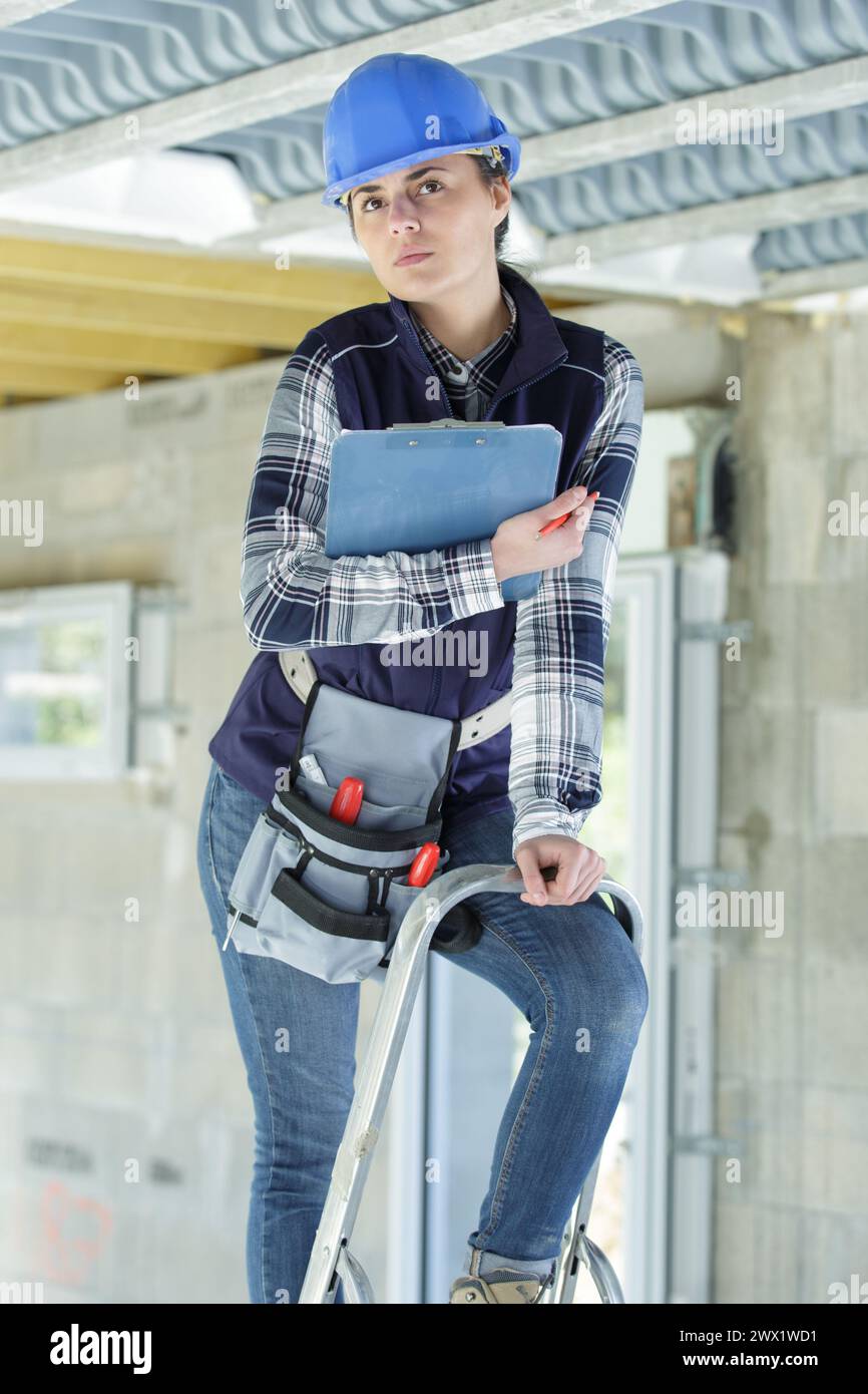 Young female builder writing hi-res stock photography and images - Alamy
