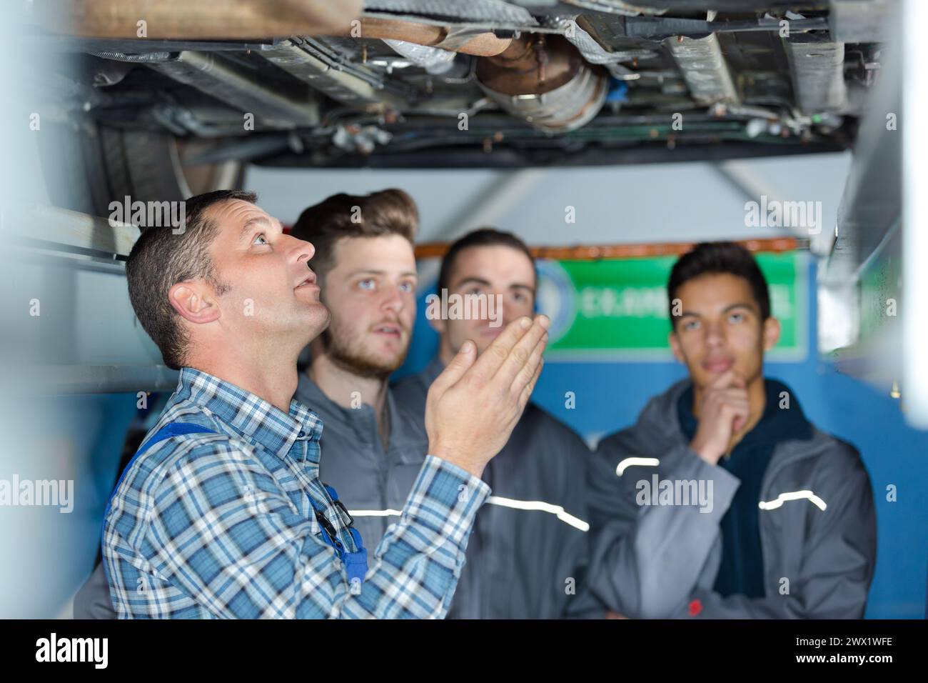 portrait of mechanics underneath car Stock Photo - Alamy